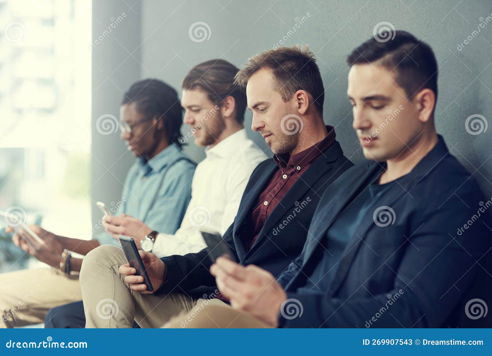 Their Devices are Keeping Them Busy while they Wait. a Group of ...