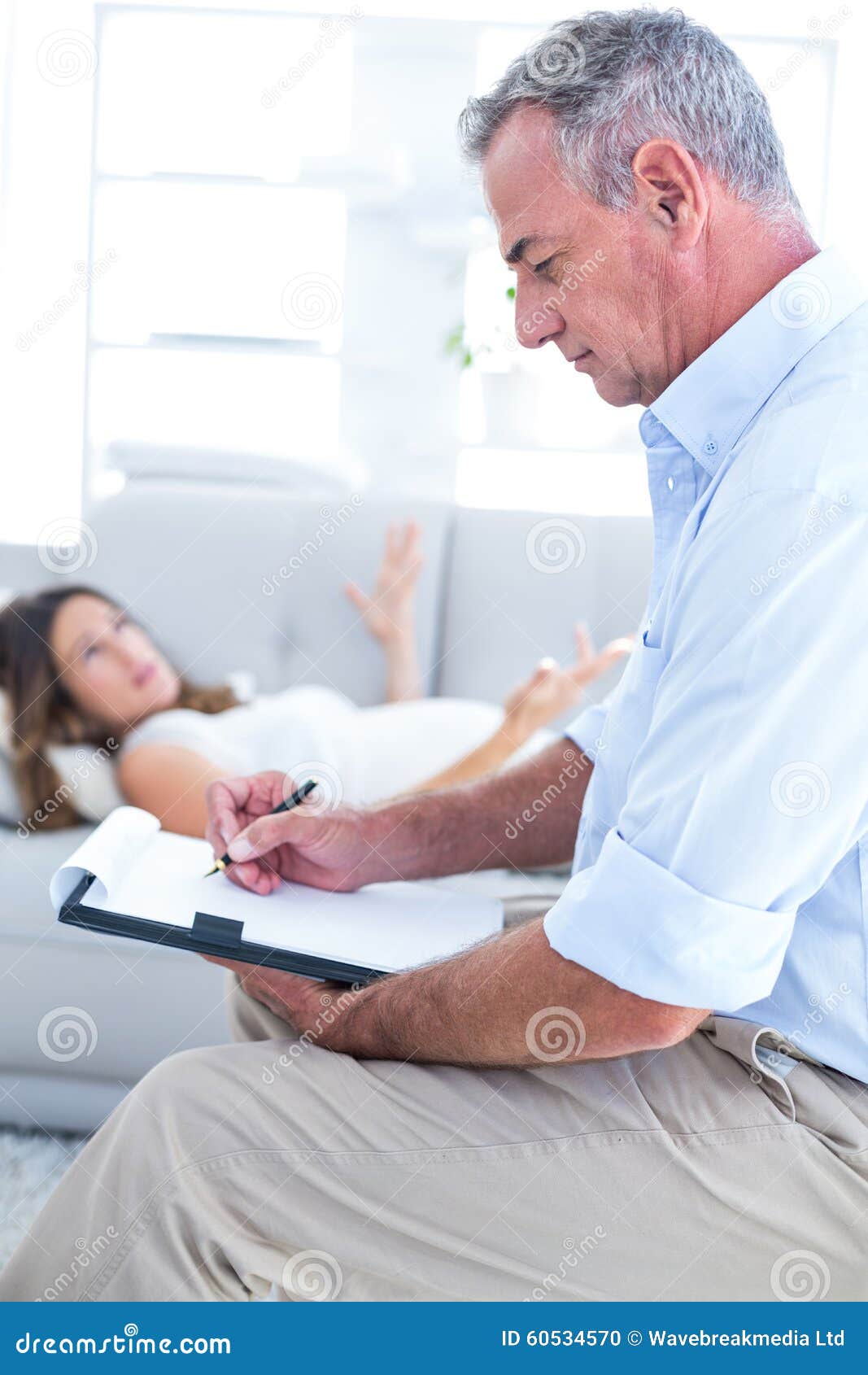 Therapist Writing on Notepad with Female Patient Stock Photo - Image of ...