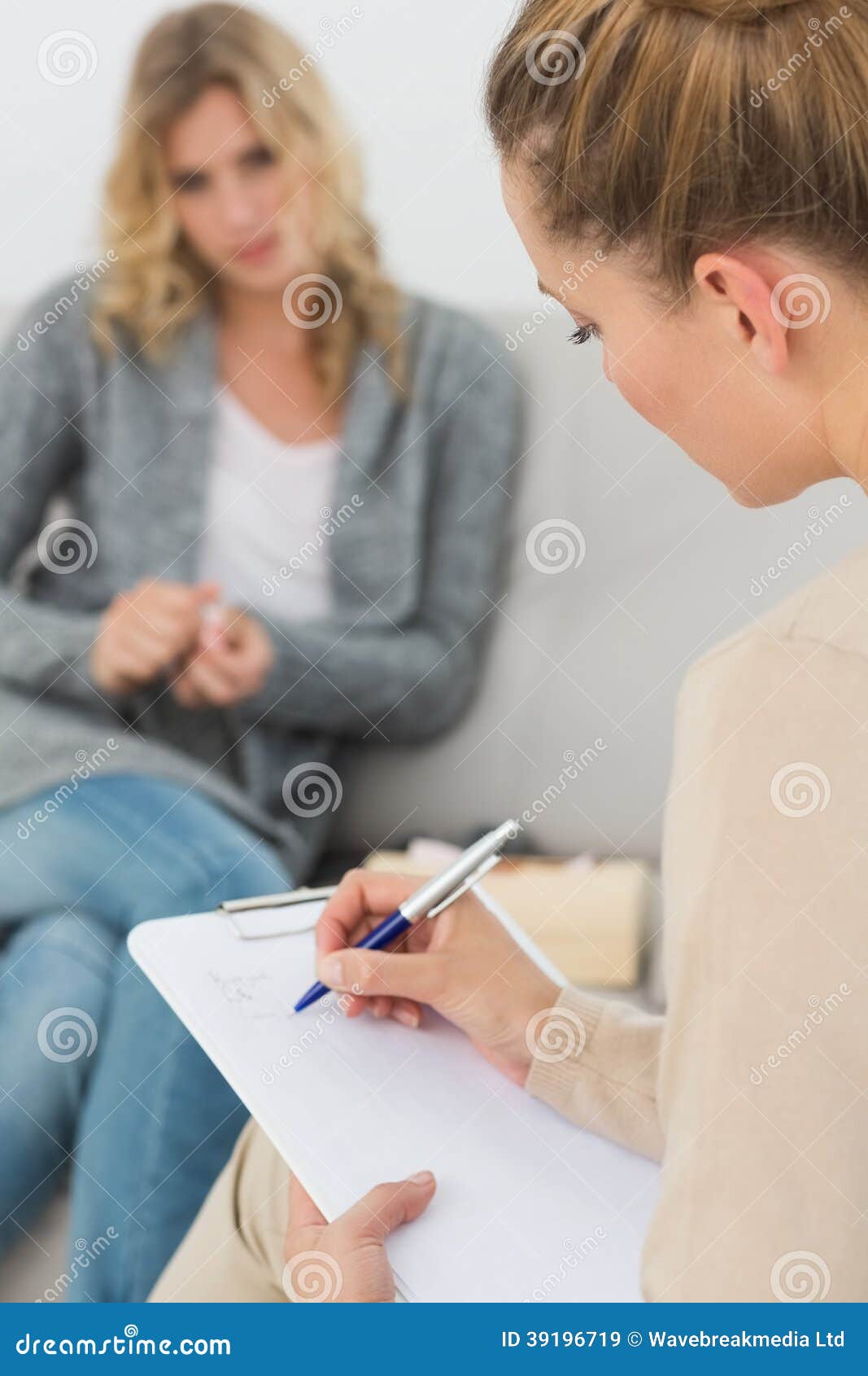 Therapist Writing Notes on Her Clipboard Stock Image - Image of indoors ...