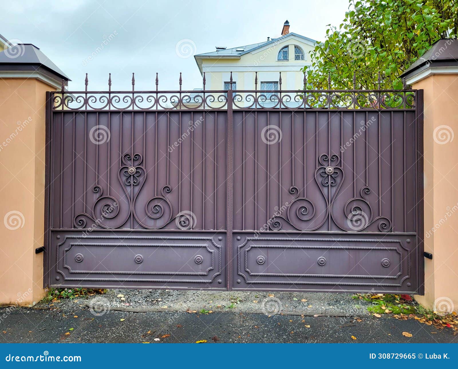 There are Brown Iron Gates with Forged Fragments between the Light ...