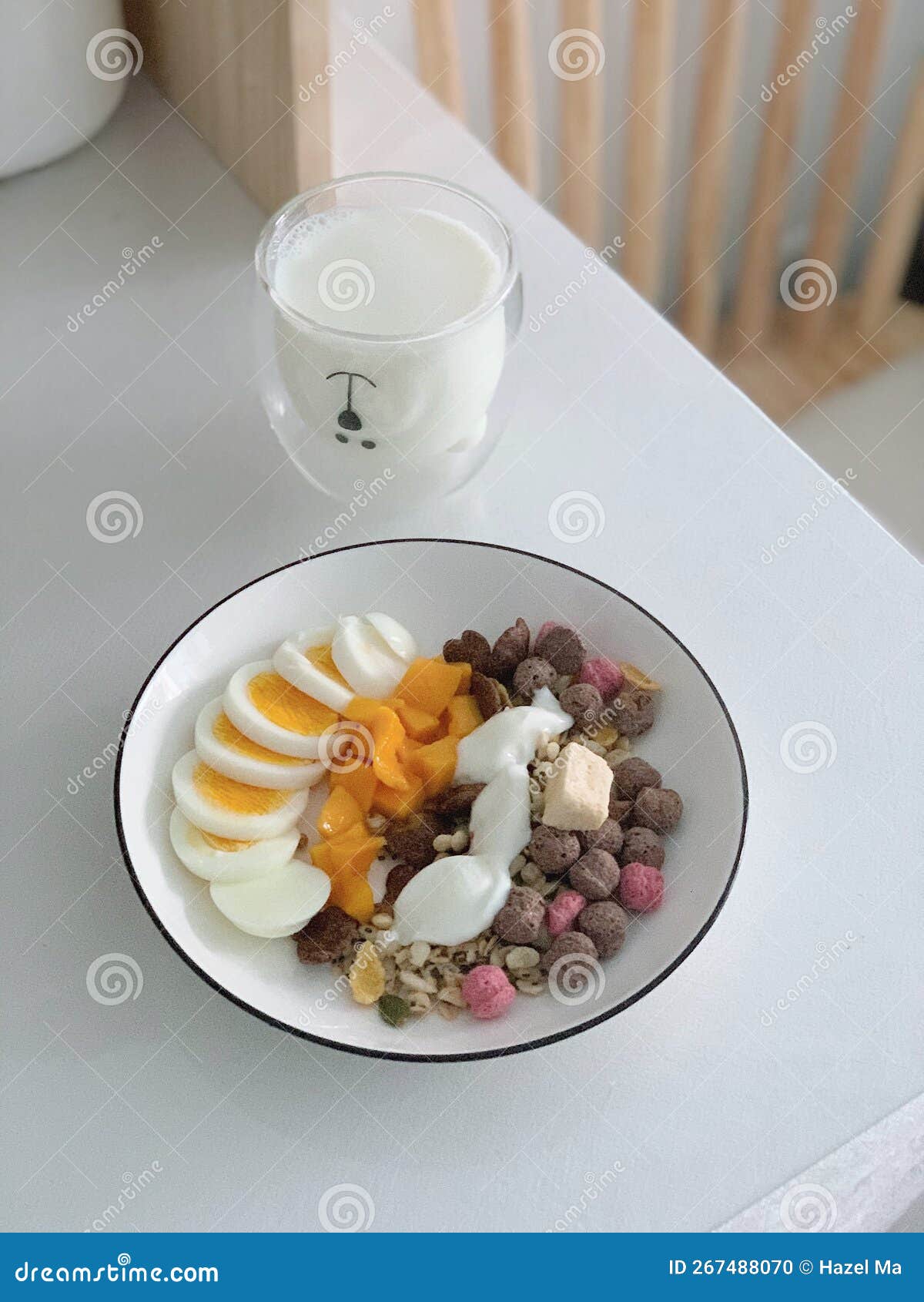 There are Some Cereal, Mango Yogurt and Cut Eggs in the White Plate ...
