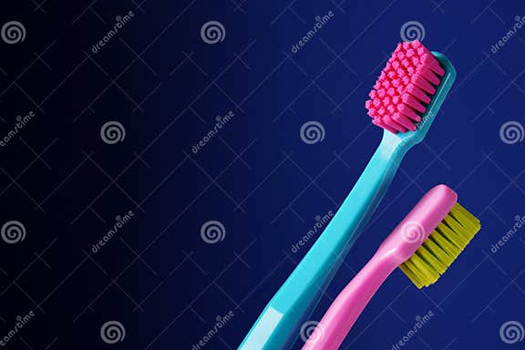Two Bright Plastic Toothbrushes on a Dark Blue Background. There is a ...
