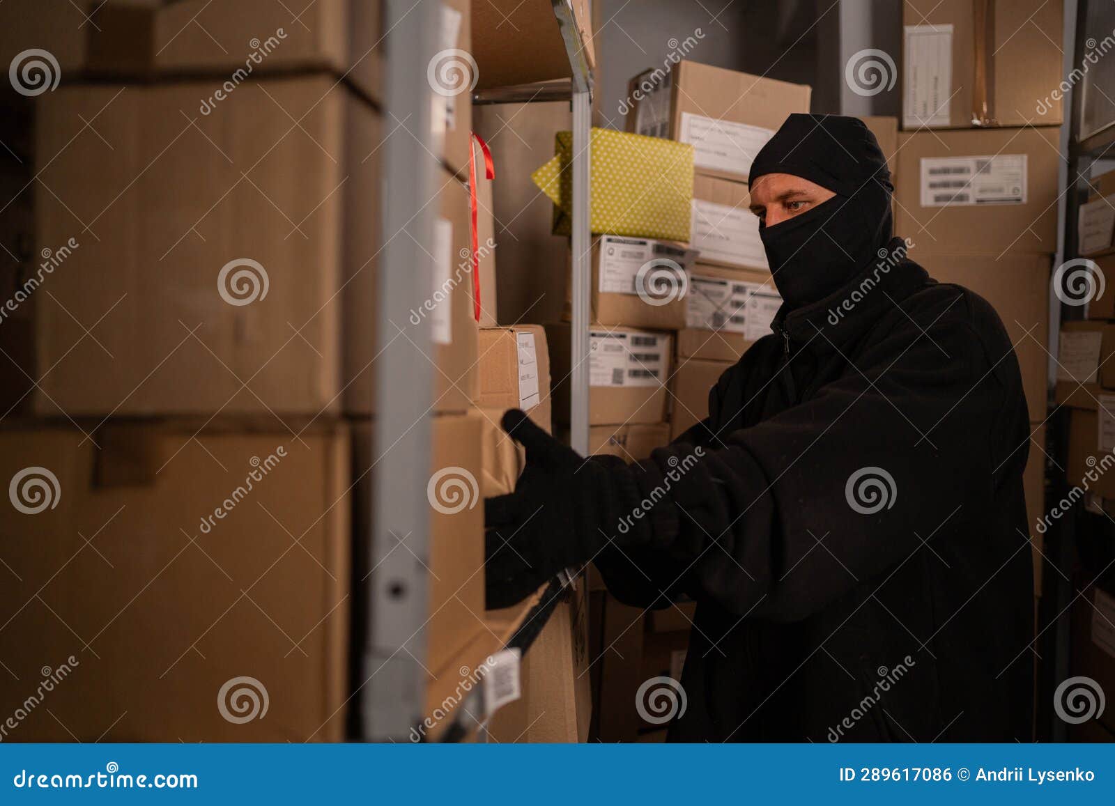 Thief in Black Gloves Take a Boxes of Goods in a Warehouse at Night ...