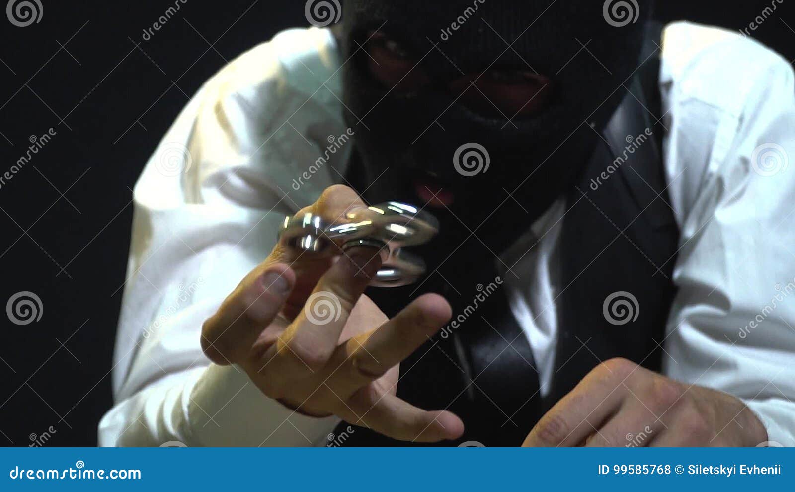 The Robber in a Black Mask and Suit is Playing with a Spinner Stock ...