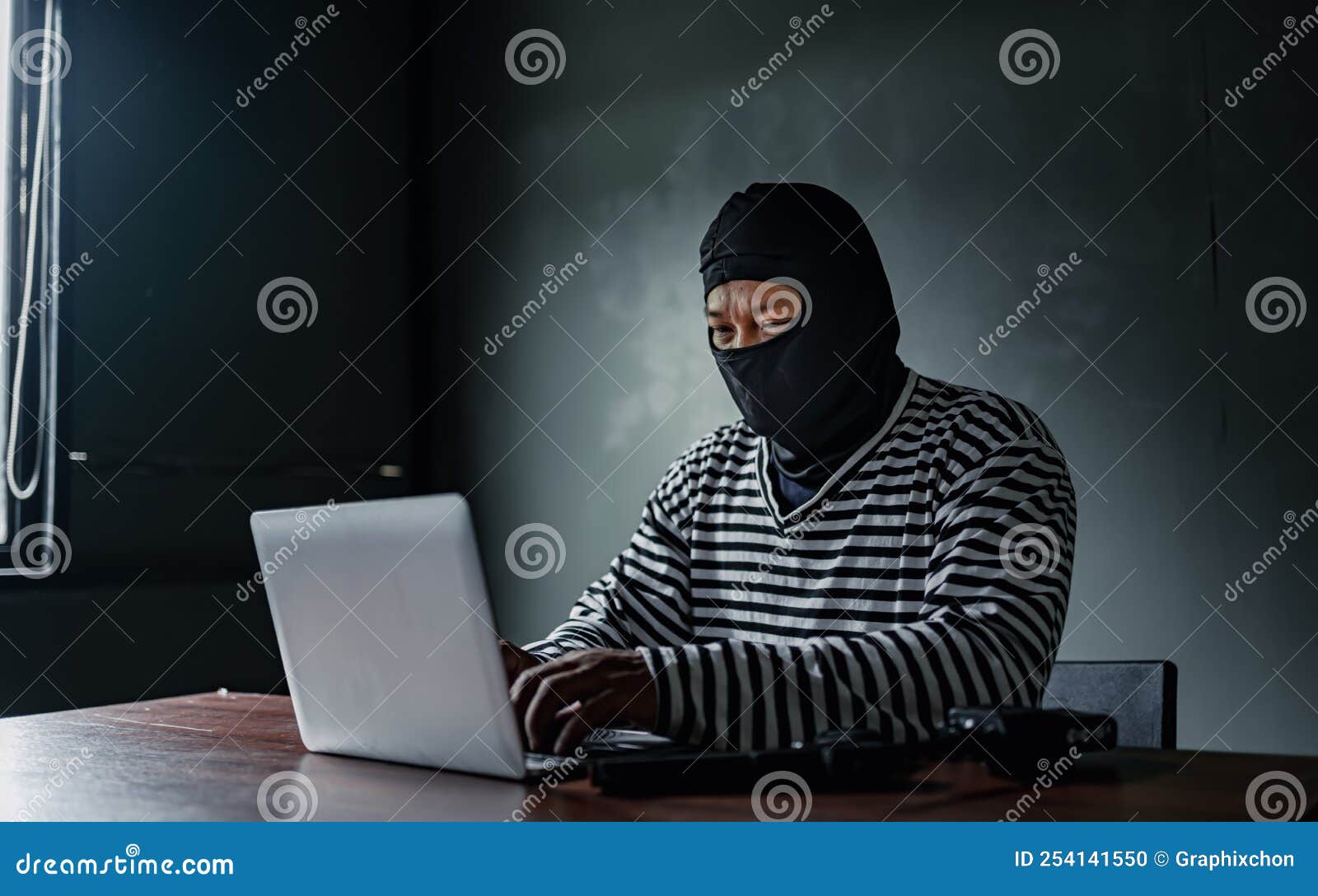 Thief Use Computer for Theft. Hacker Stealing Data from a Laptop ...