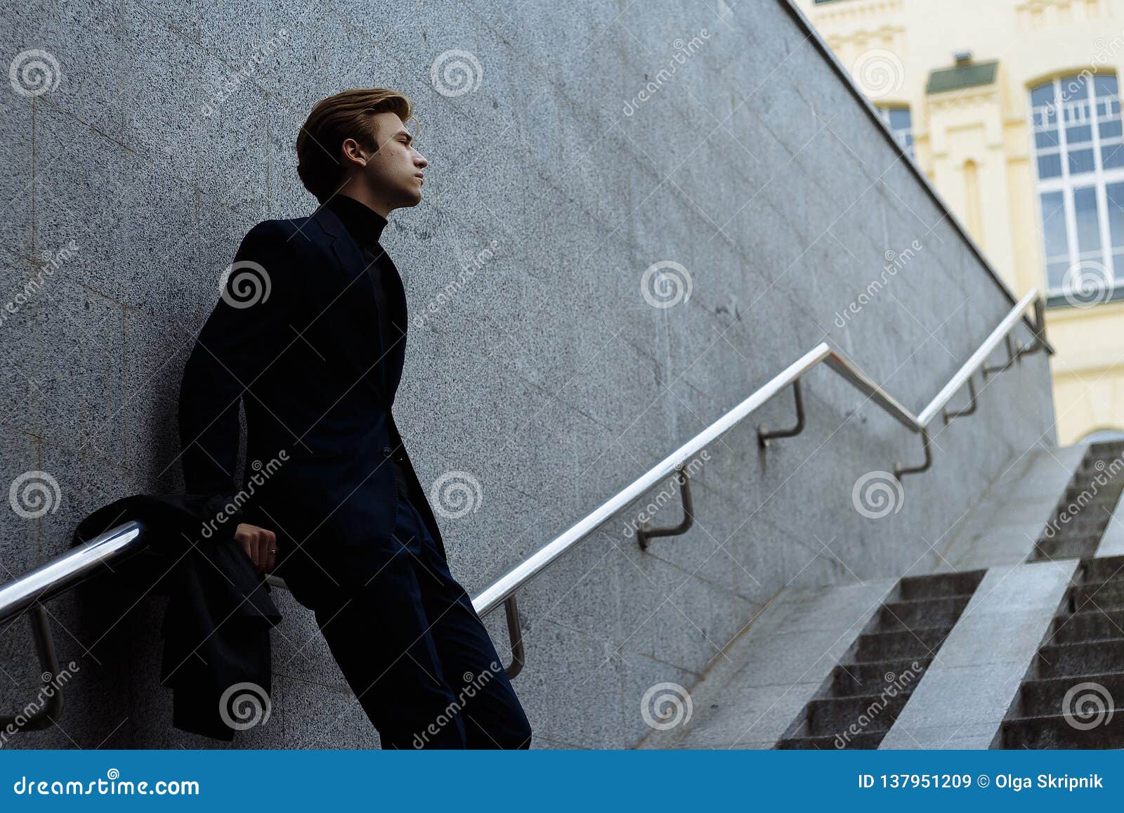 Thin, Attractive Man is Leaning on the Railing, on the Stairs. Looking ...