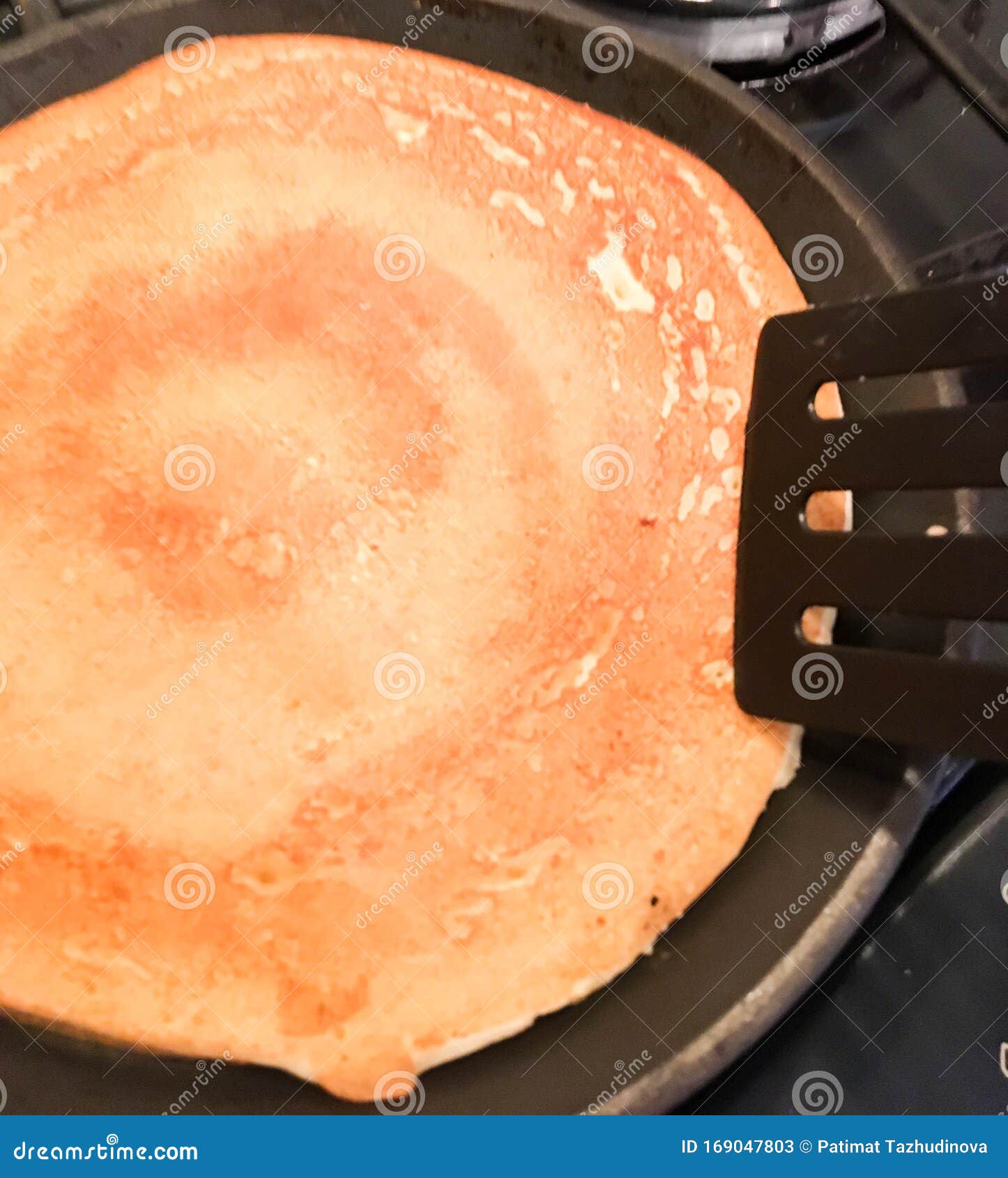 A Thin Layer of Pancake is Fried in a Pan. Cooking Pancakes on Fire ...