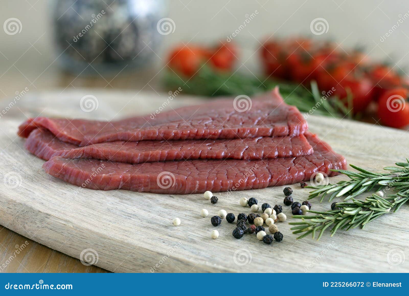 Thin Slices of Lean Beef on a Cutting Board with Pepper and Rosemary ...