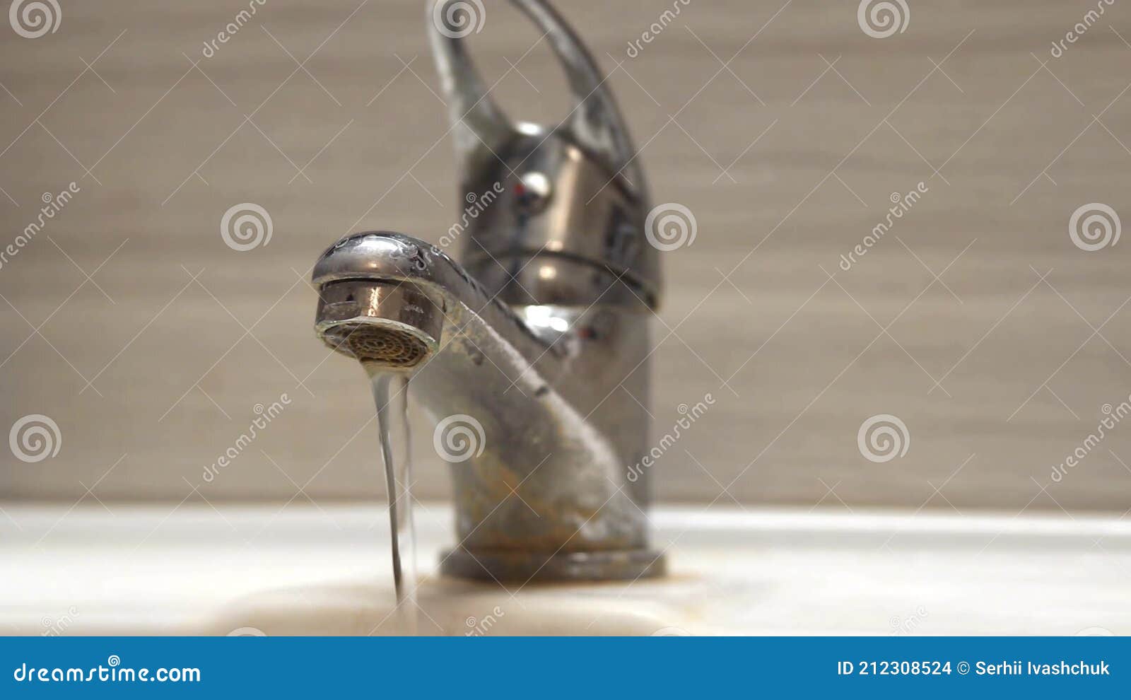 A Thin Stream Of Hard Water Flows From An Old Tap Aerator Stock