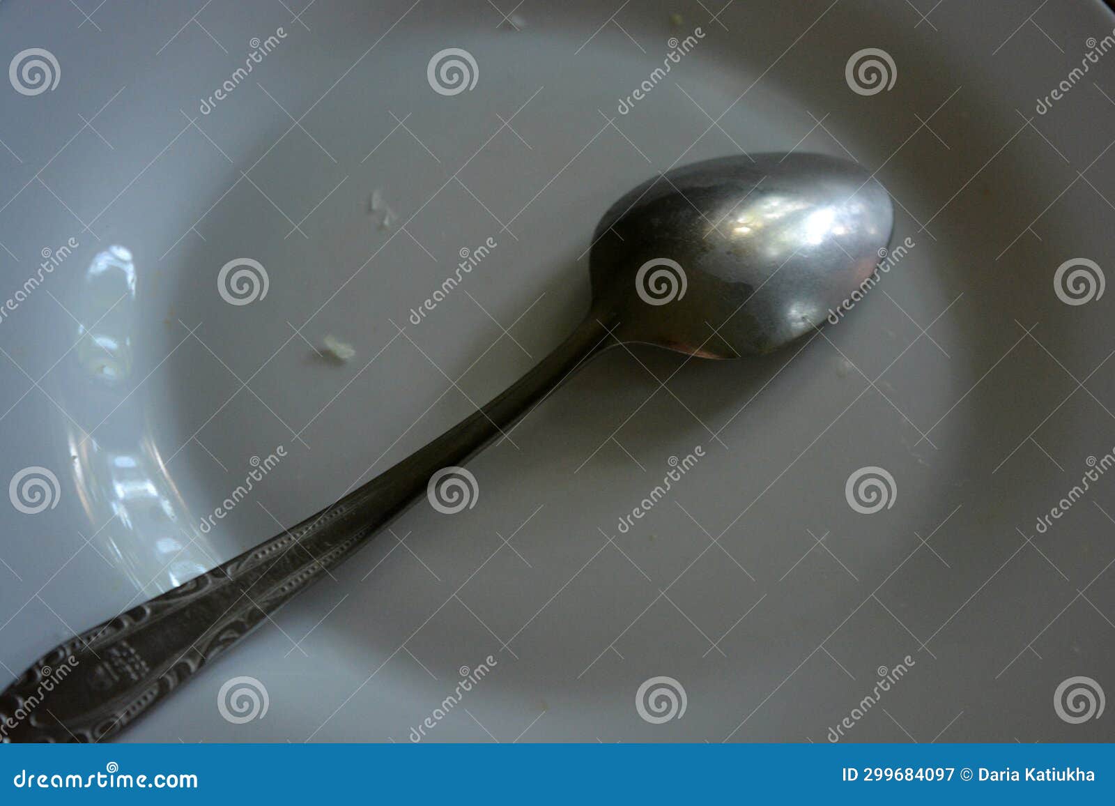 A Large Glass Glossy White Plate with a Large Metal Spoon on it ...