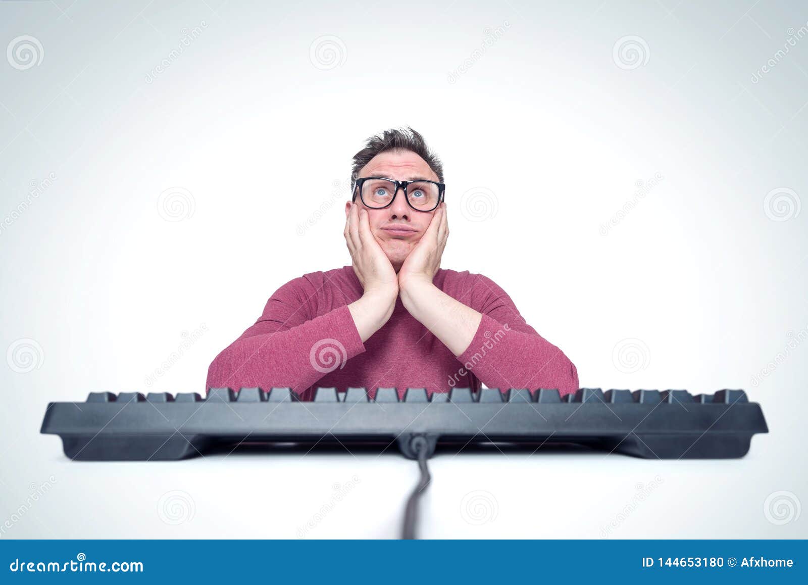 Thinking Man in Glasses Behind a Keyboard in Front of a Computer ...