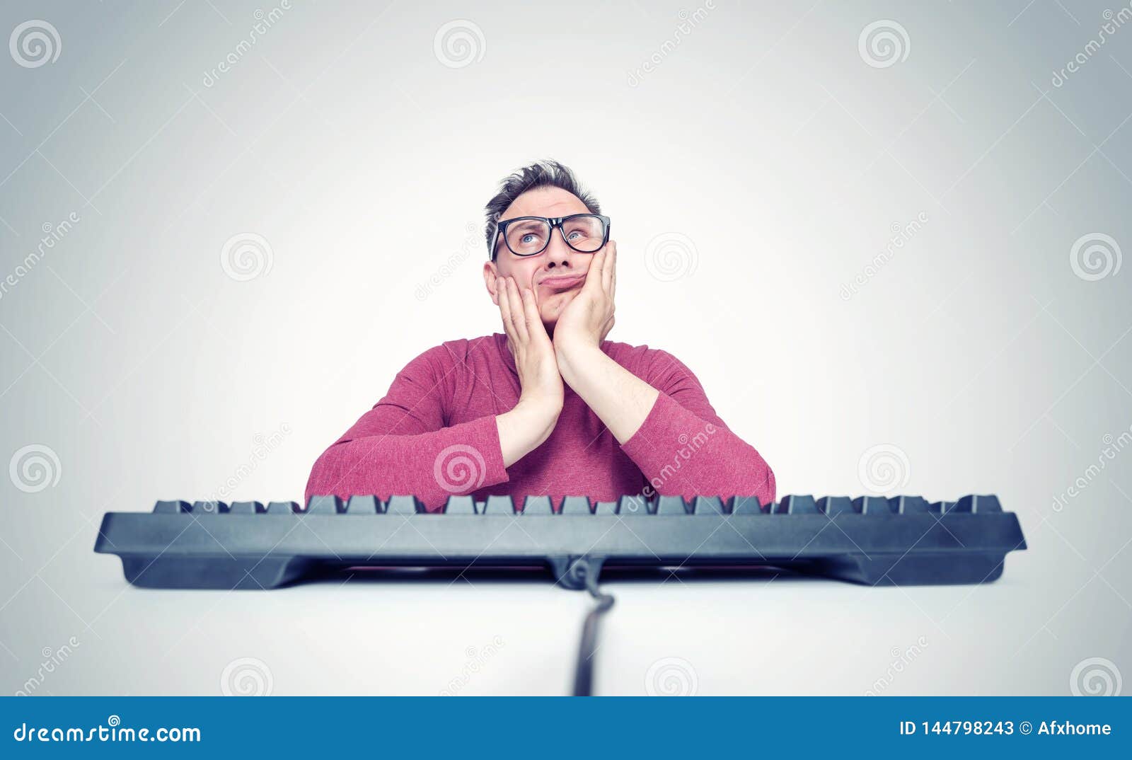 Thinking Man in Glasses Behind a Keyboard in Front of a Computer ...