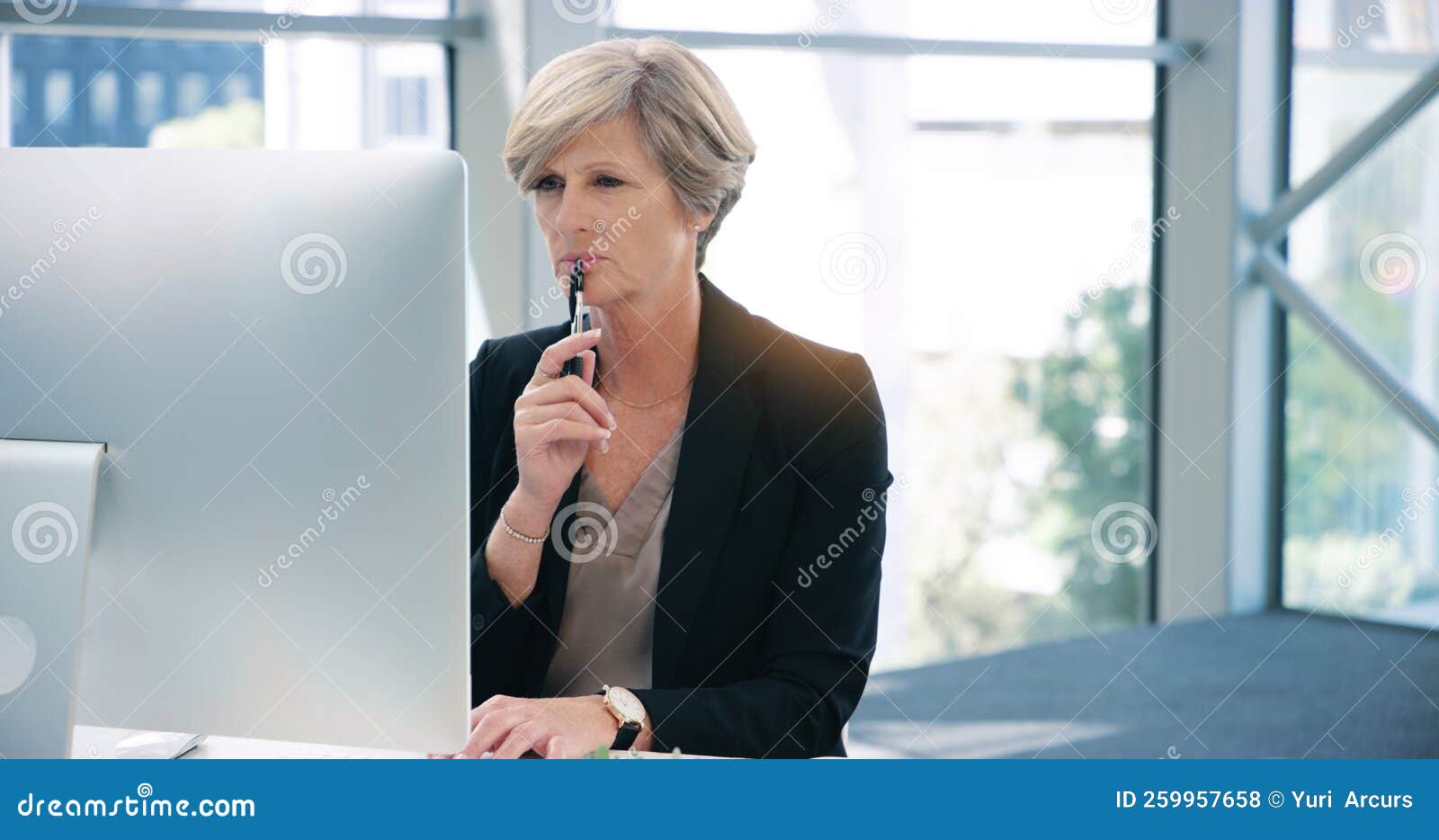 Thinking through the Possibilities. a Mature Businesswoman Working on a ...