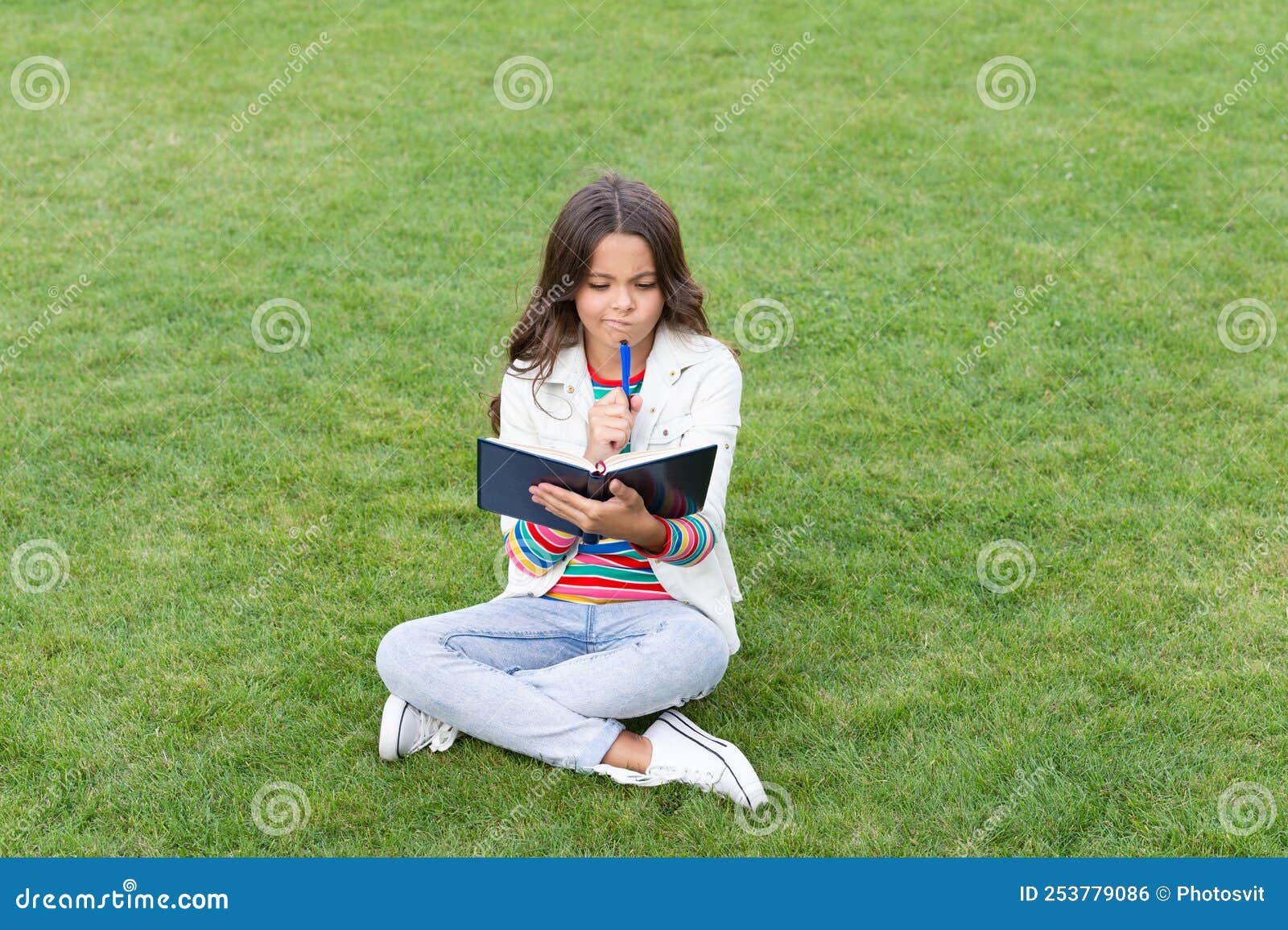 Thinking Teen Child Making Notes in Notebook Sitting on Grass. Taking ...