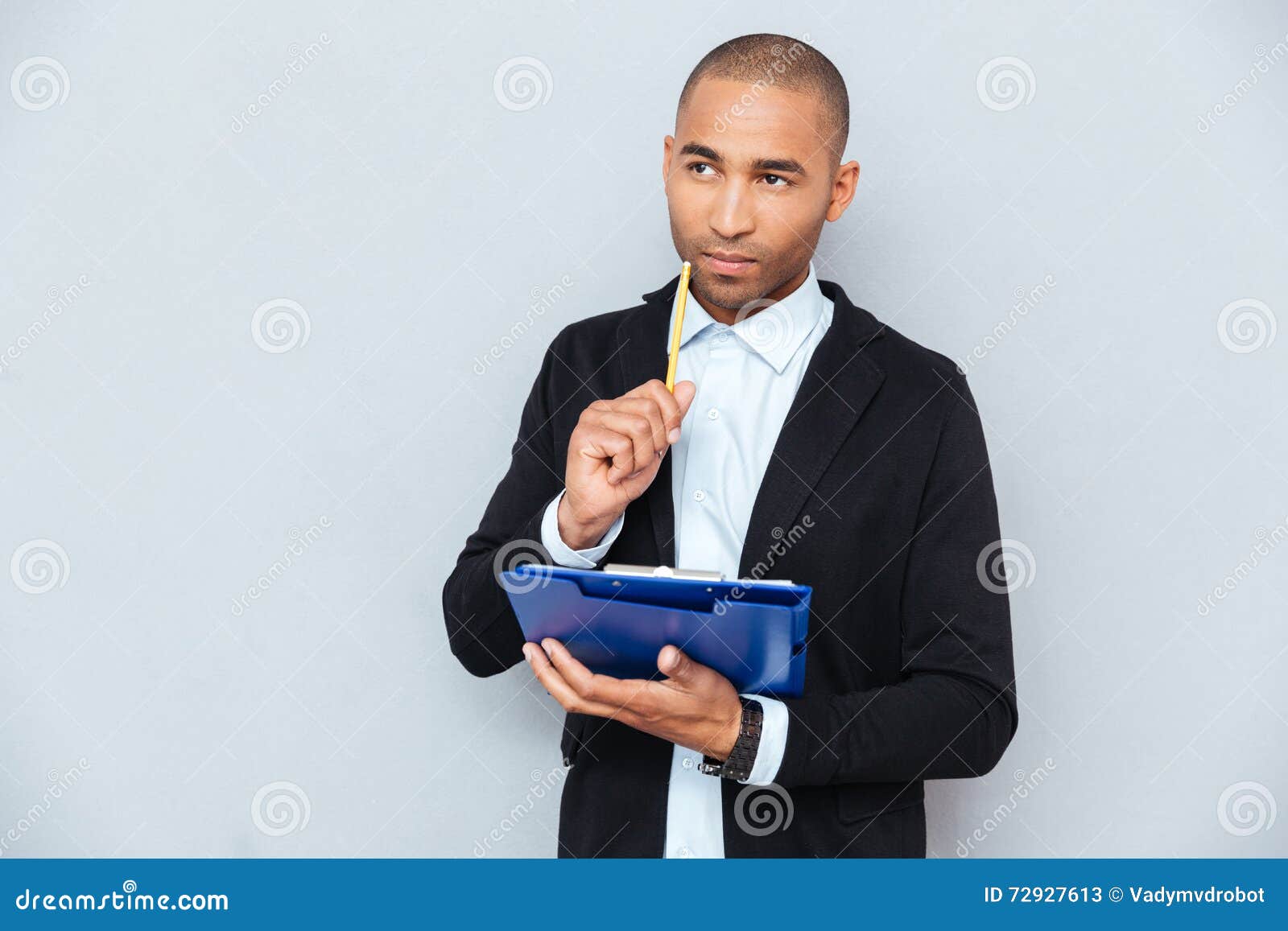 Thoughtful African Young Man Writing on Clipboard Stock Image - Image ...