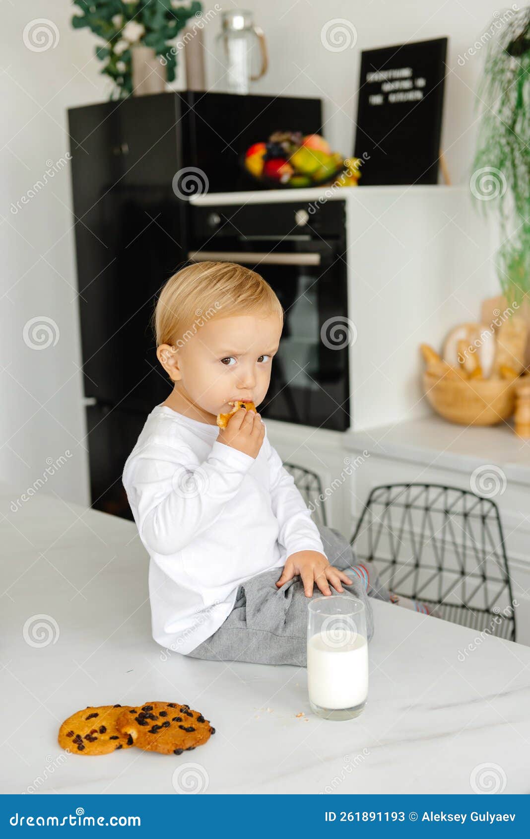 Thoughtful, Angry Boy Eats Breakfast Cookies and Milk and Looks at the ...