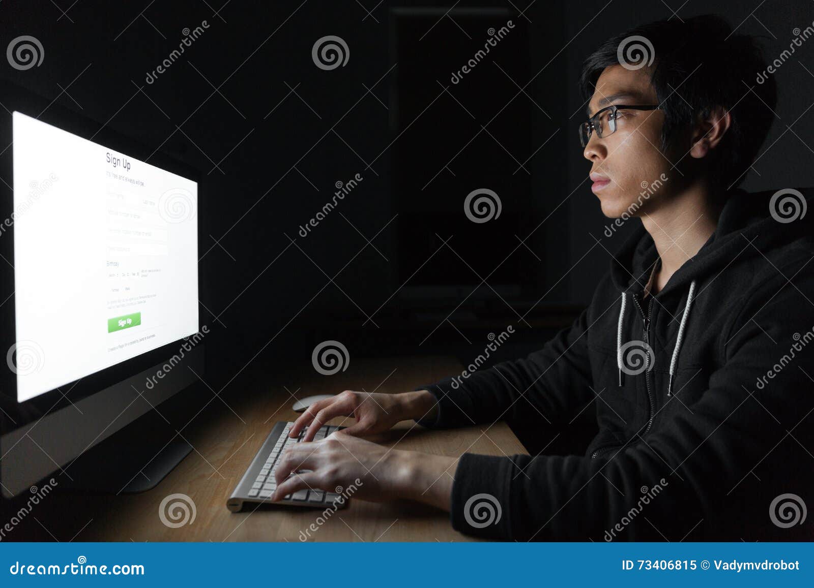 Thoughtful Asian Man Using Computer at Table in Dark Room Stock Image ...