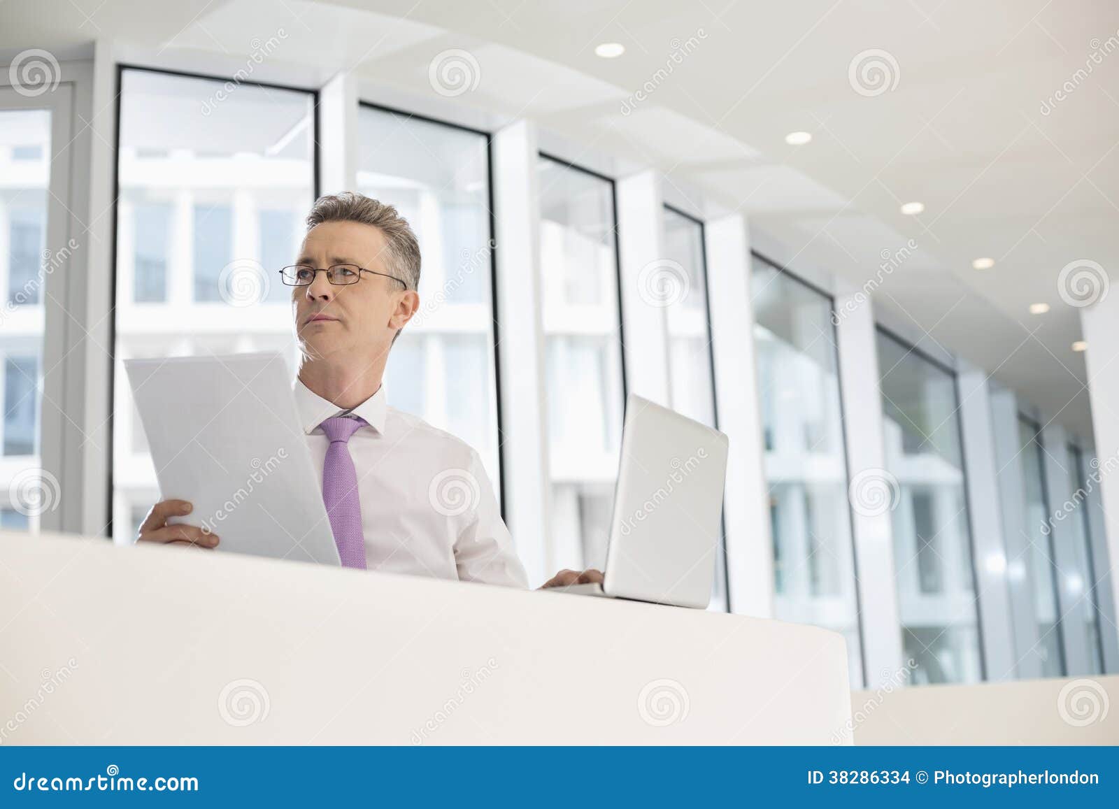 Thoughtful Businessman with Laptop and Documents at Railing Stock Photo ...