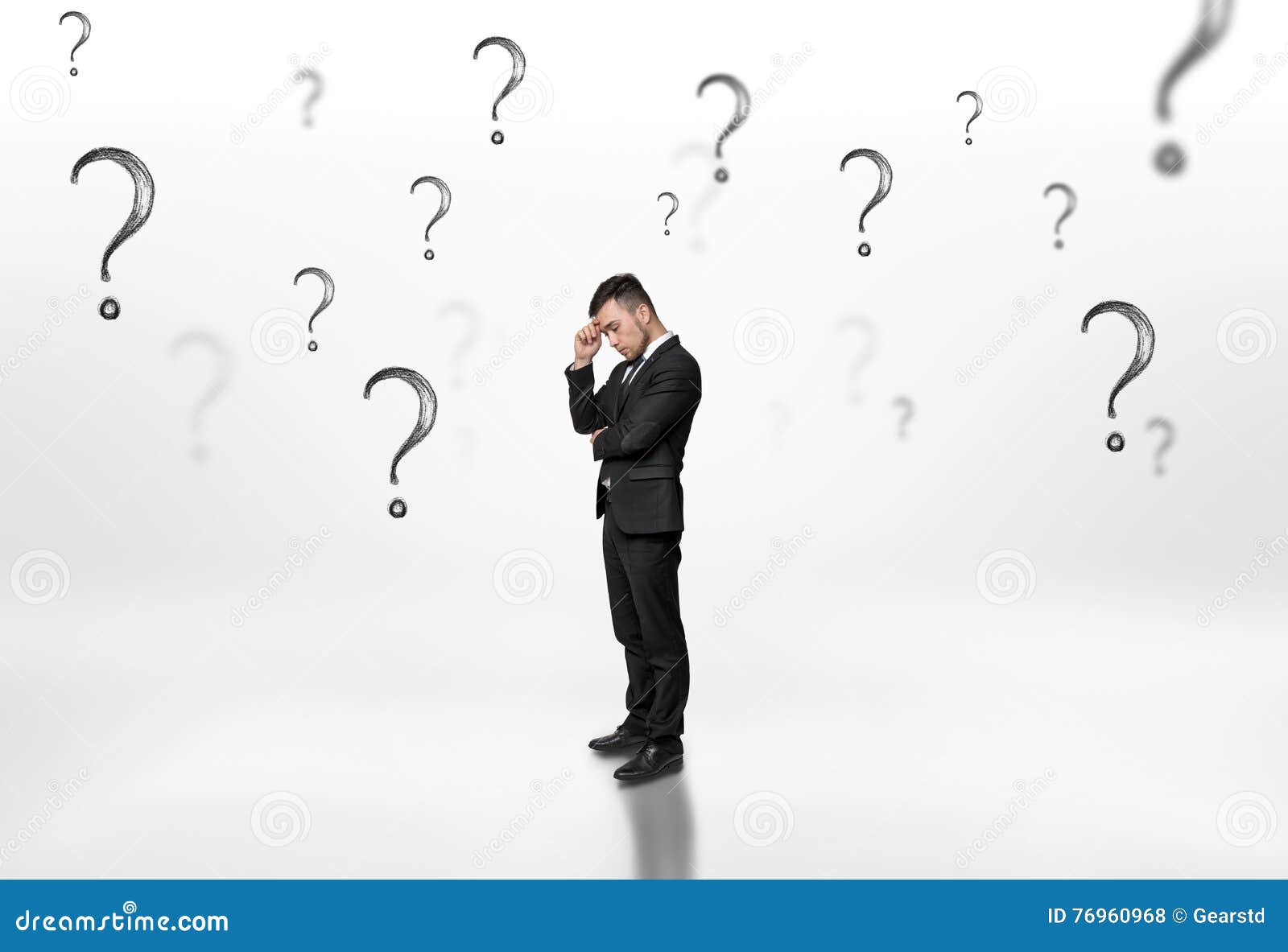 Thoughtful Businessman Looking Upwards Surrounded by Question Marks on ...