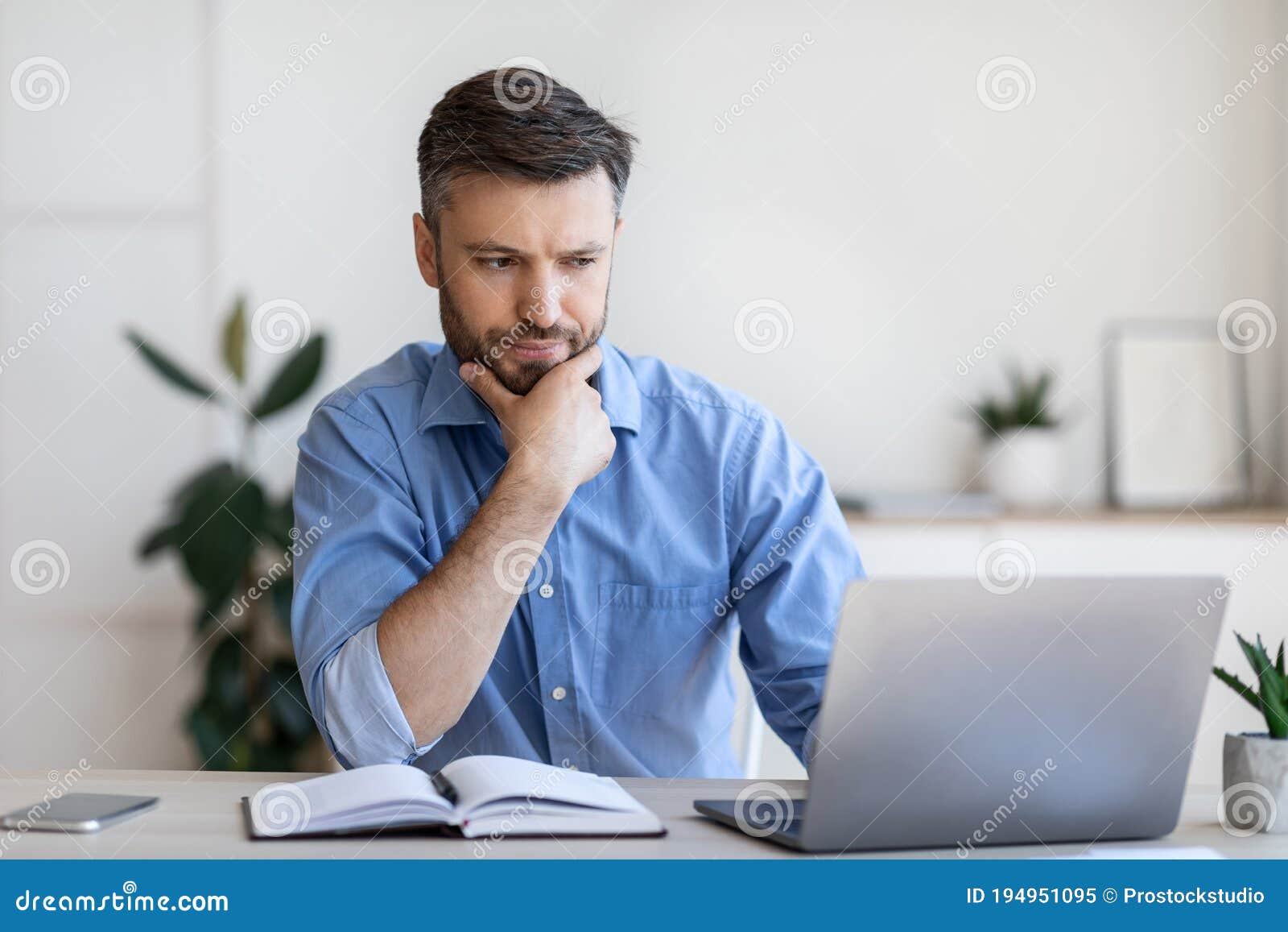 Thoughtful Businessman Working with Computer in Office, Looking at ...