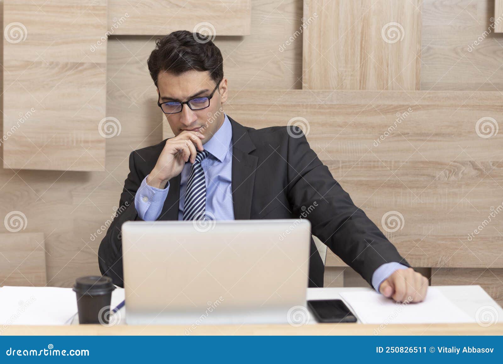 Thoughtful Handsome Business Man Working on Laptop in the Modern Office ... Thoughtful Handsome Business Man Working on Laptop in the Modern Office ...