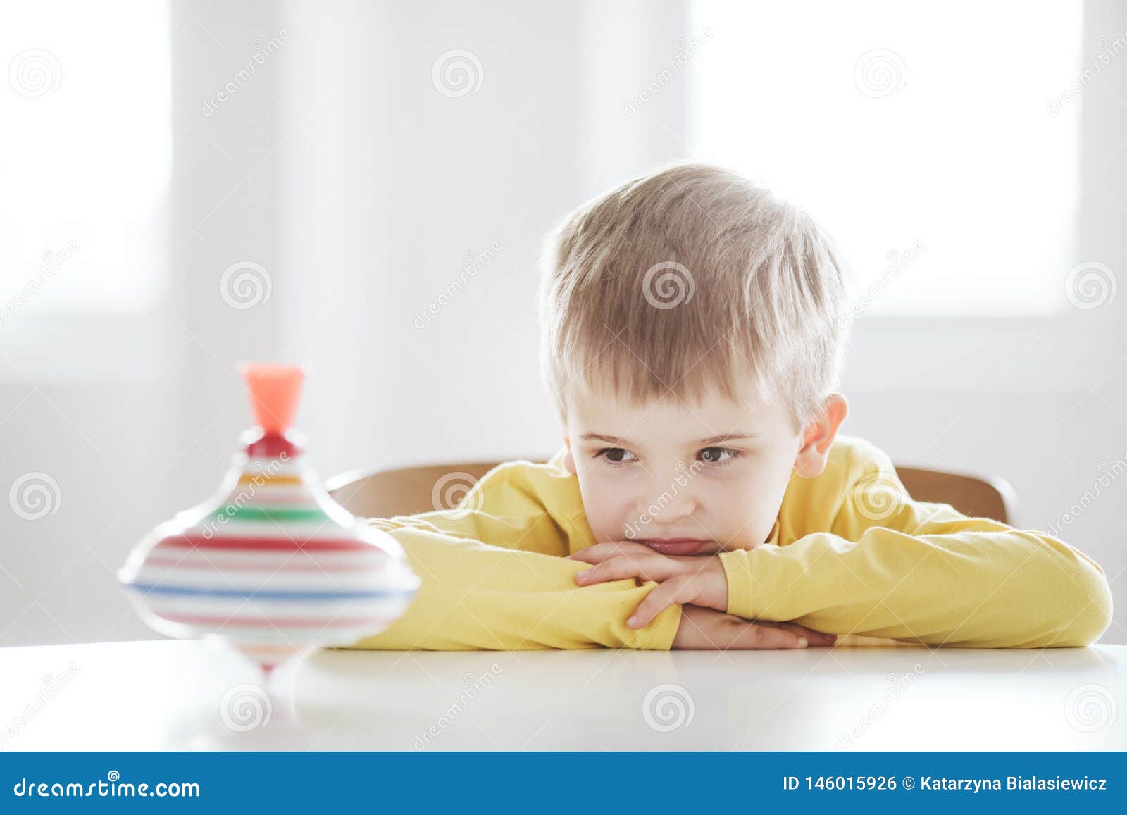 Thoughtful Boy Sits at the Table and Looks at the Spinning Top Stock ...