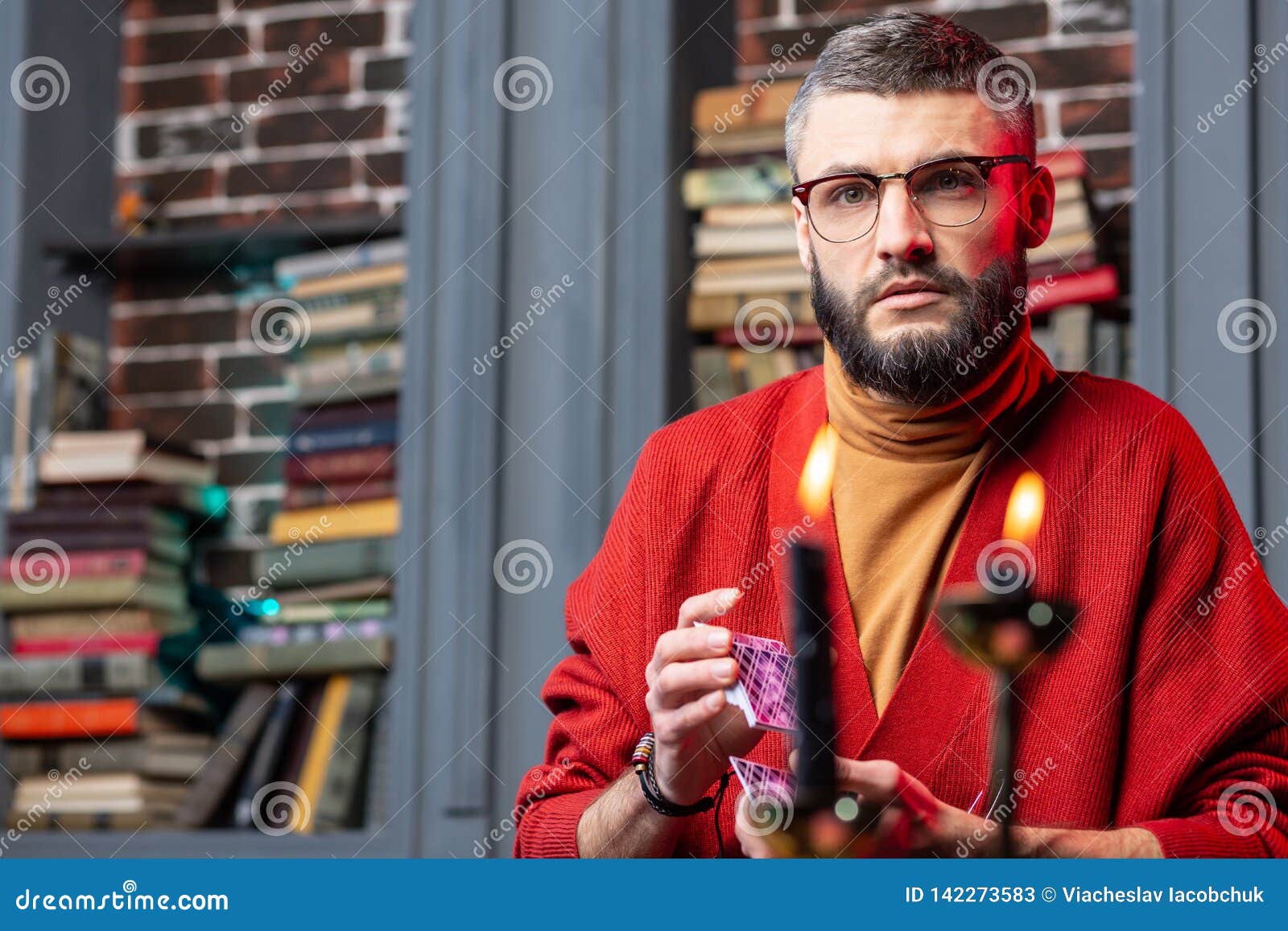 Thoughtful Magician Feeling Inspired while Holding Predicting Cards ...