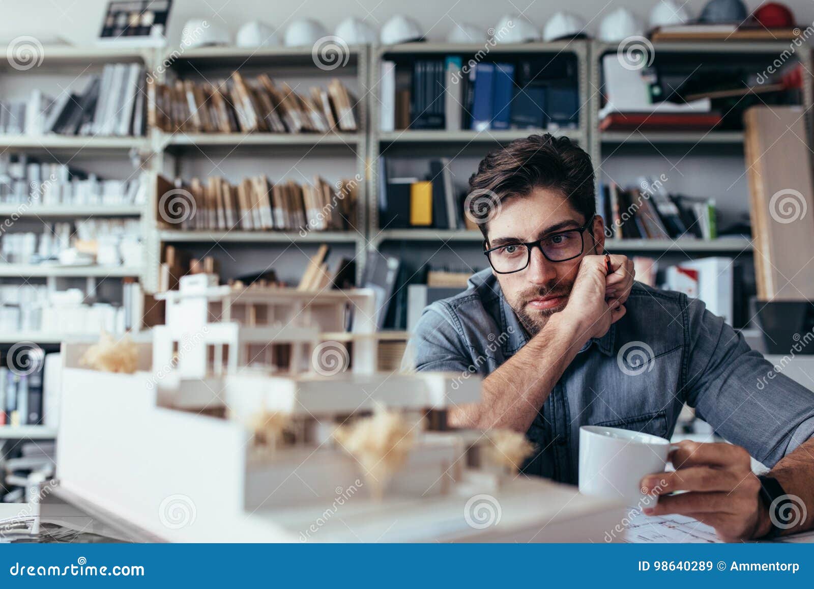 Thoughtful Male Designer Looking at Model with Cup of Coffee Stock ...