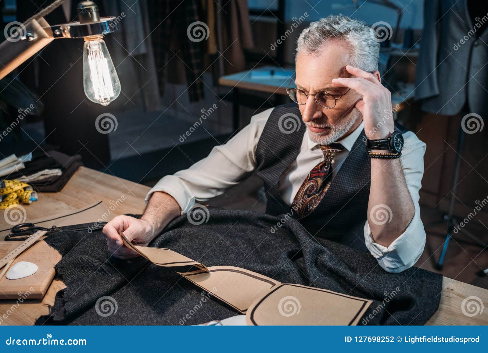 Thoughtful Mature Tailor Sitting at Workplace at Sewing Workshop Stock ...
