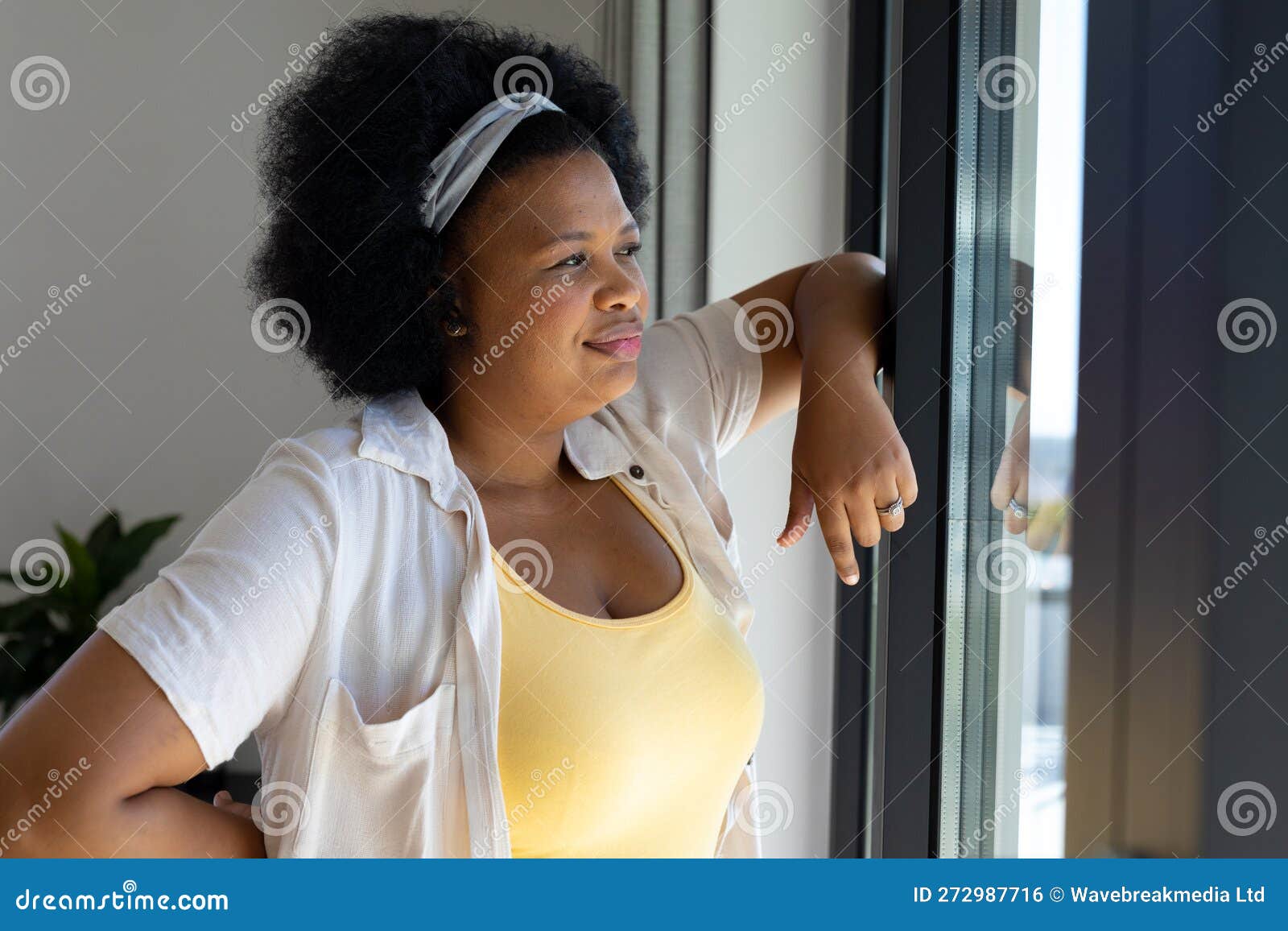 Thoughtful Plus Size African American Woman Looking Through Window And