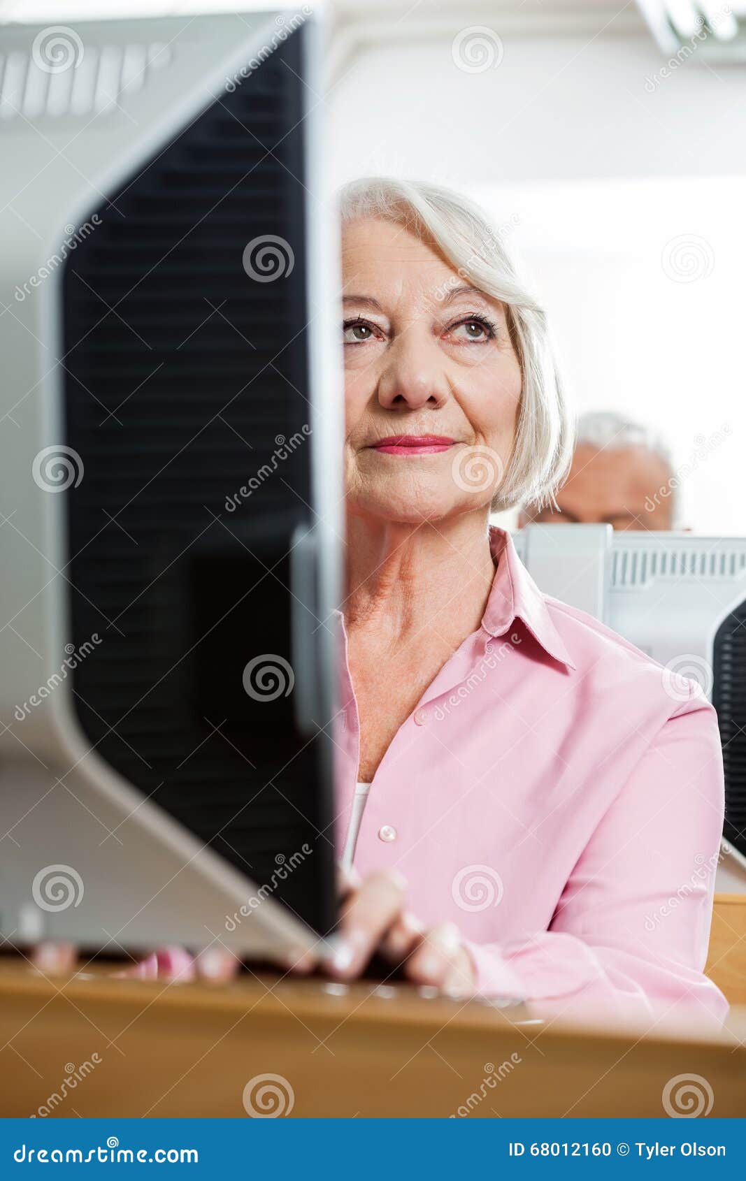 Thoughtful Senior Woman Using Computer in Classroom Stock Photo - Image ...