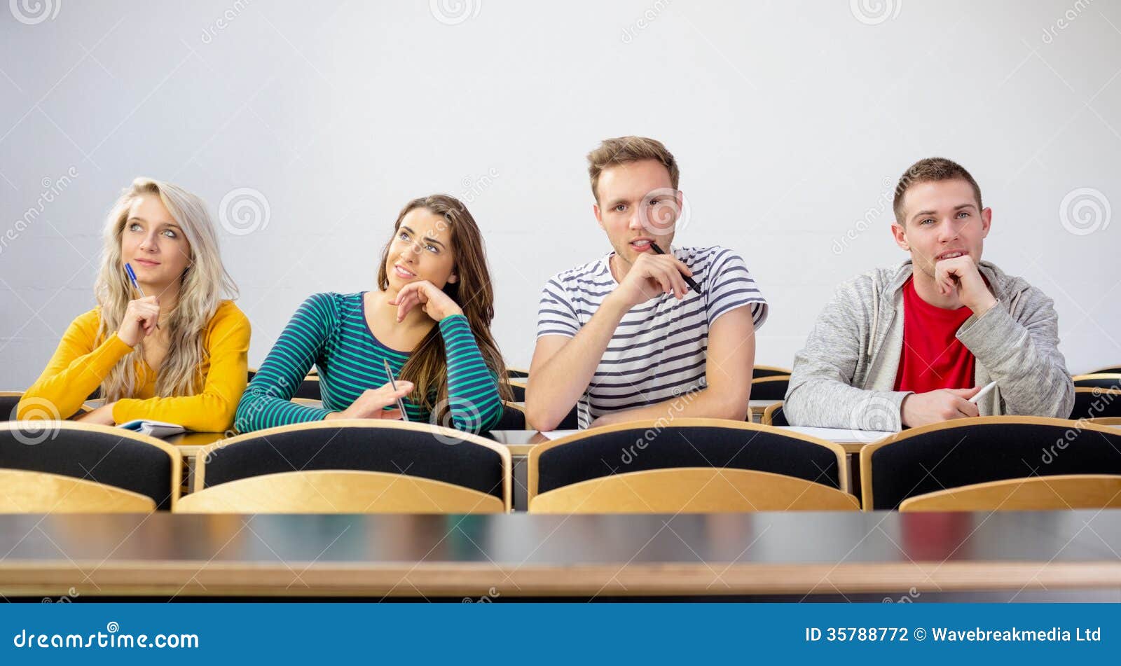 Thoughtful Smiling College Students in Classroom Stock Photo - Image of ...