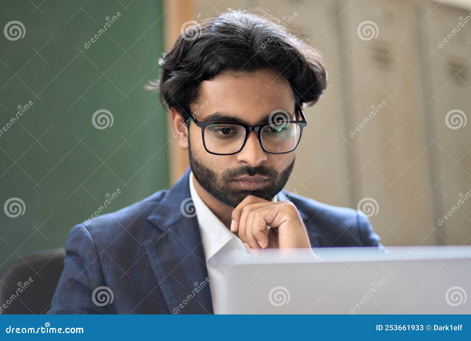 Thoughtful Young Indian Business Man Analyzing Market Data, Looking at ...