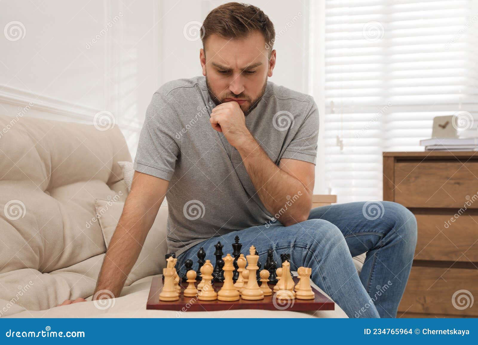 Thoughtful Young Man Playing Chess Alone on Sofa at Home Stock Photo ...