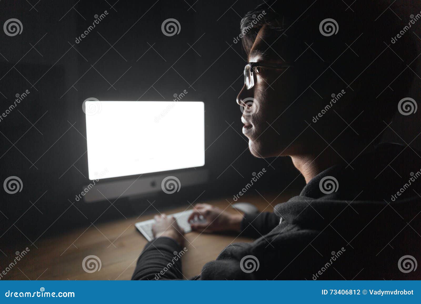 Thoughtful Young Man Using Blank Screen Computer in Dark Room Stock ...