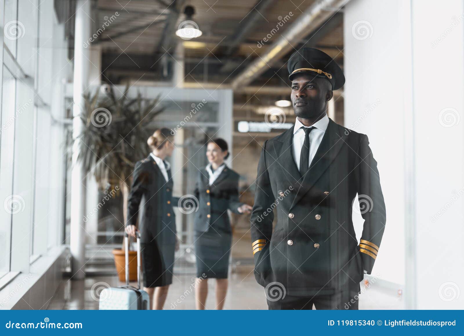 Thoughtful Young Pilot in Airport with Stewardesses Stock Photo - Image ...