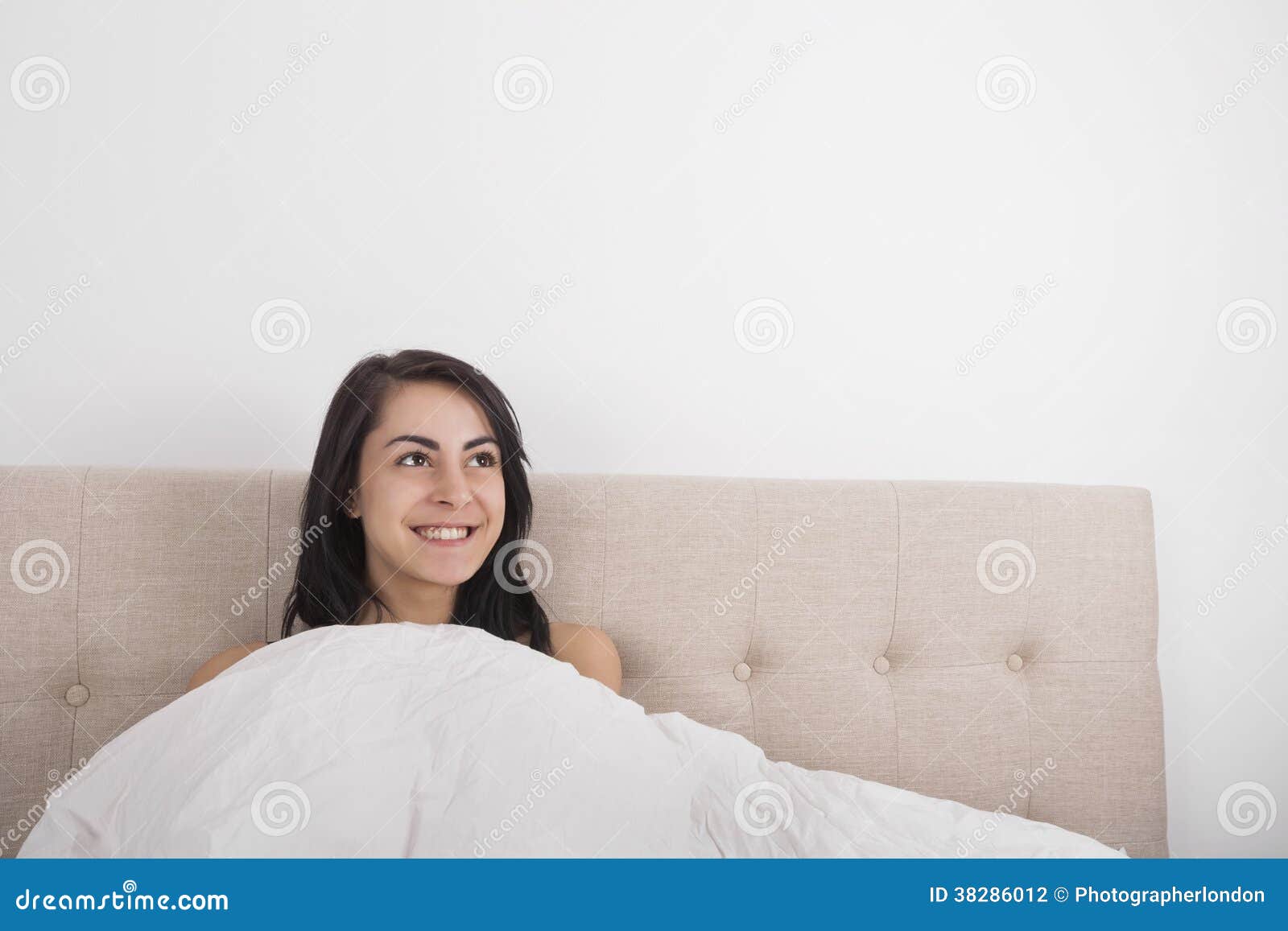 Thoughtful Young Woman Smiling in Bed Stock Photo - Image of ...