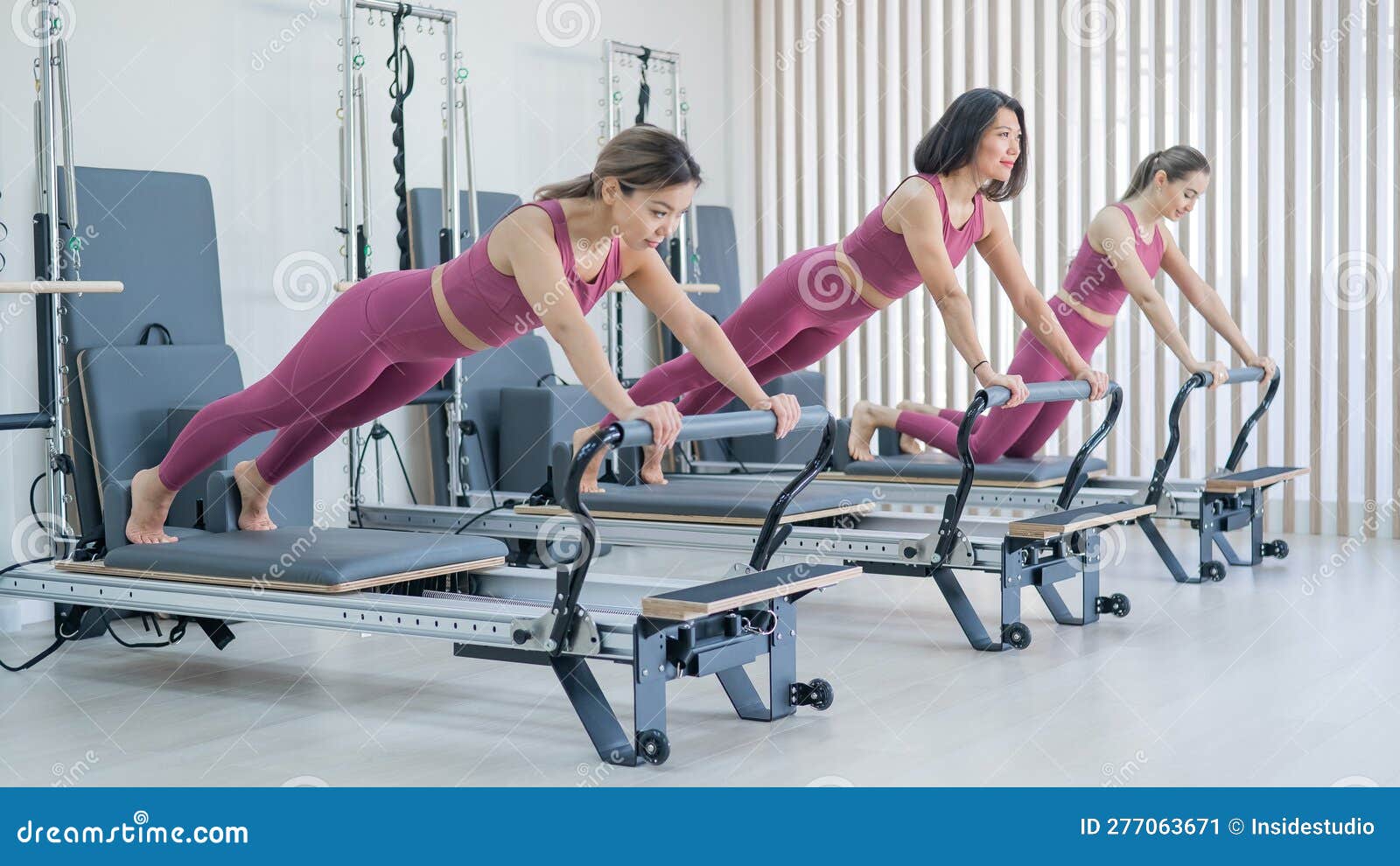 Three Asian Women Doing Plank on Reformer Machine. Stock Image - Image ...