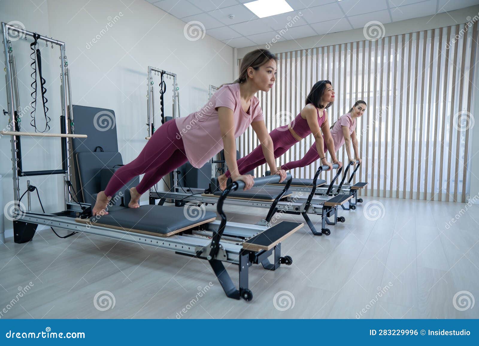 Three Asian Women Doing Plank on Reformer Machine. Stock Photo - Image ...