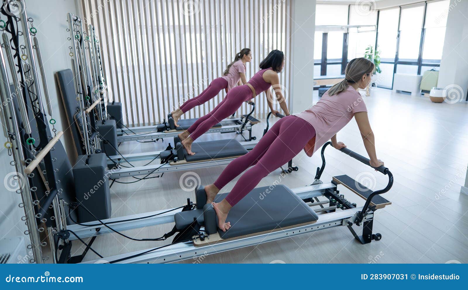 Three Asian Women Doing Plank on Reformer Machine. Stock Image - Image ...