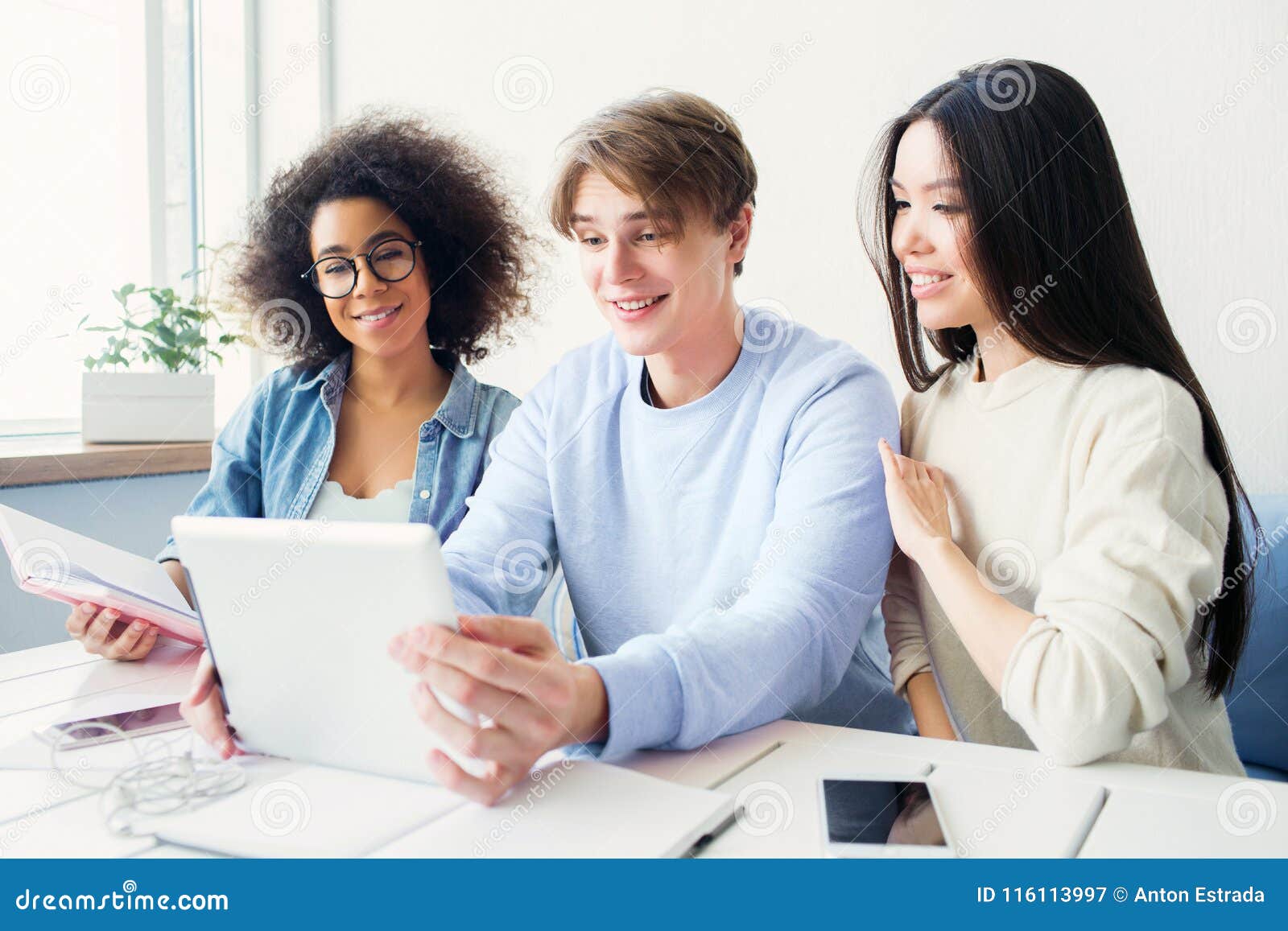 Three Beautiful Students are Sitting at the Table and Looking To the ...