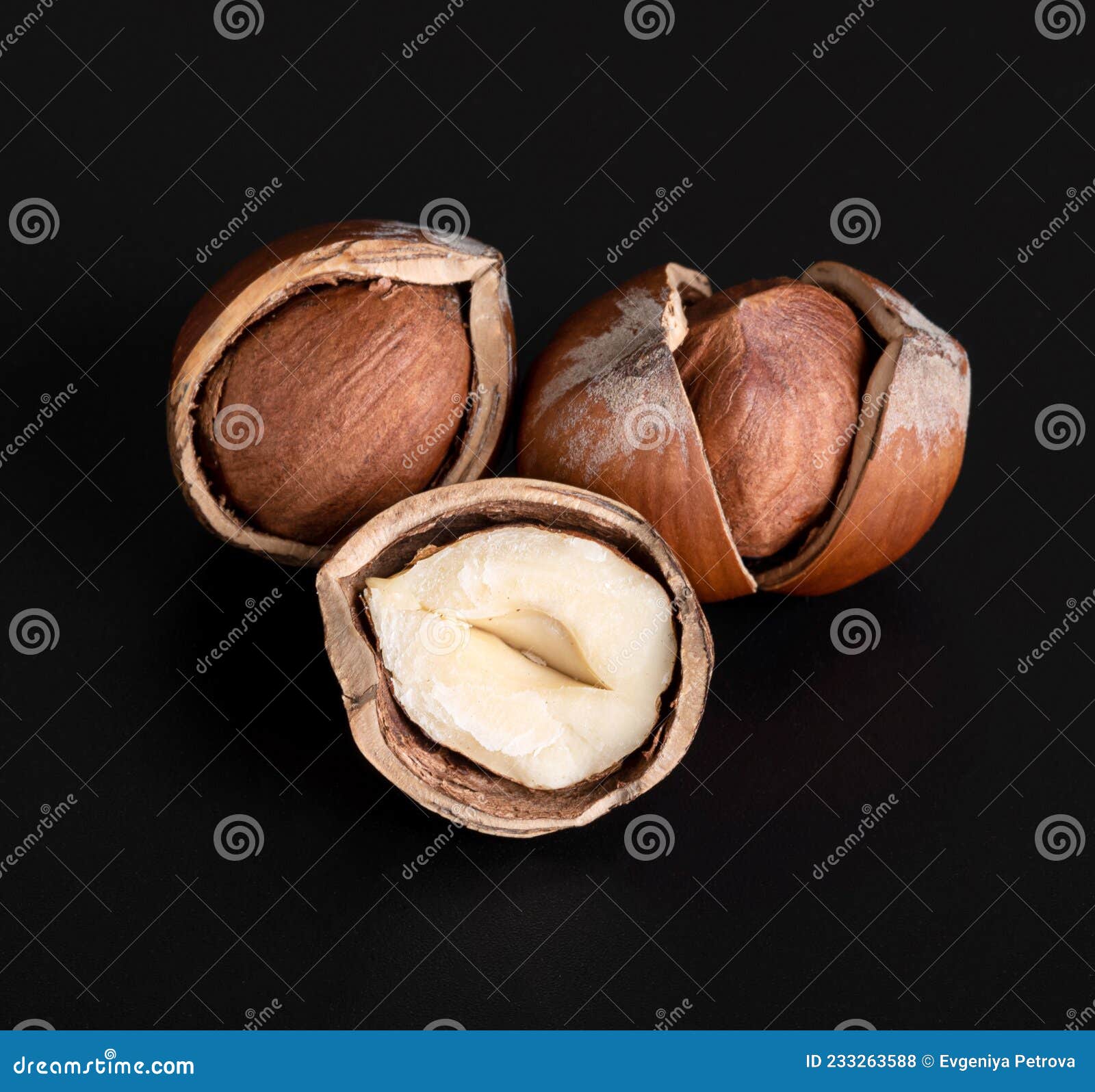Three Beautiful Young Cracked Nuts Close-up on a Glossy Black ...