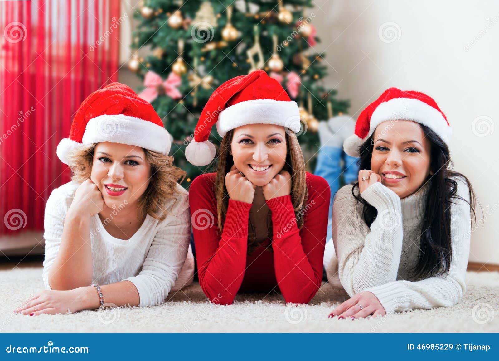 Three Beautiful Young Women Lying in Front of a Christmas Tree Stock ...