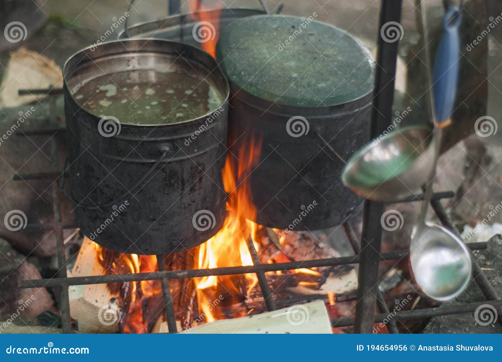 Three Blackened Cauldrons Over The Campfire. Cooking Over An Open Fire ...