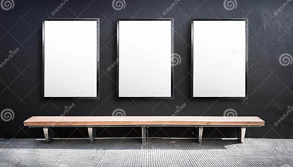 Three Blank Vertical Posters on a Black Wall with a Bench in Front ...