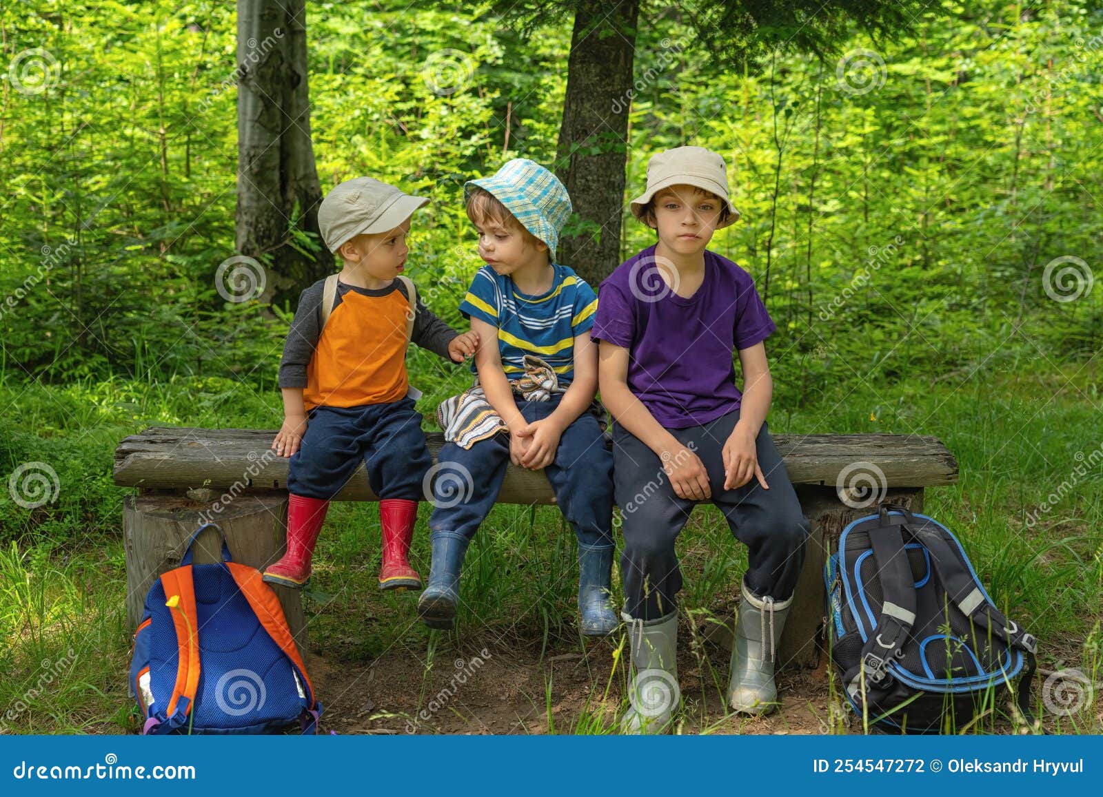 Three Boys are Sitting on a Bench. they Rest during the Journey Stock ...