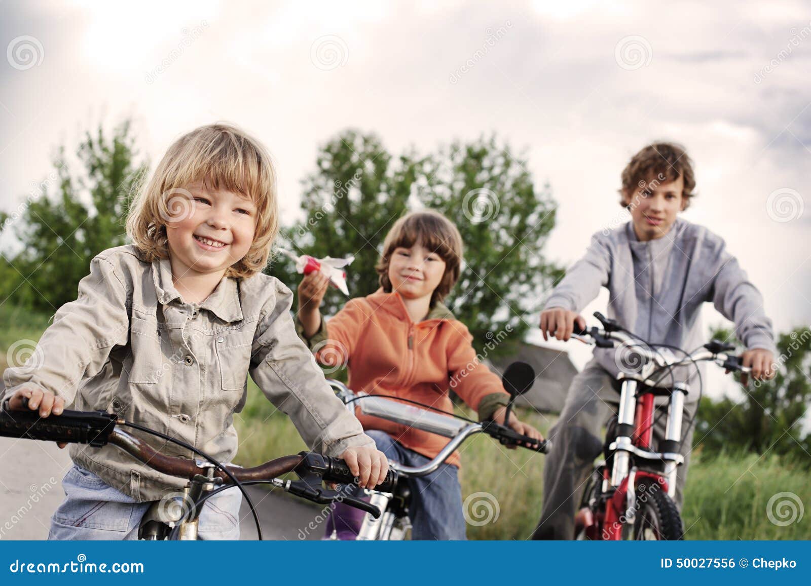 Three brothers ride bikes stock photo. Image of male - 50027556