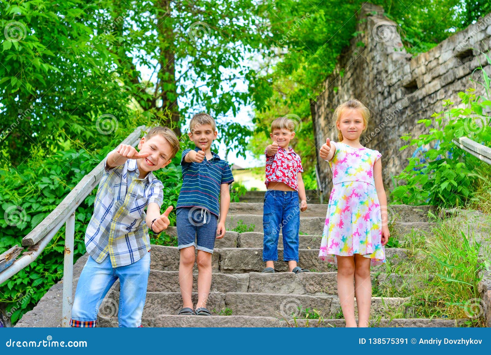 Three Brothers and Sister Stand on the Steps in the Park and Show the ...