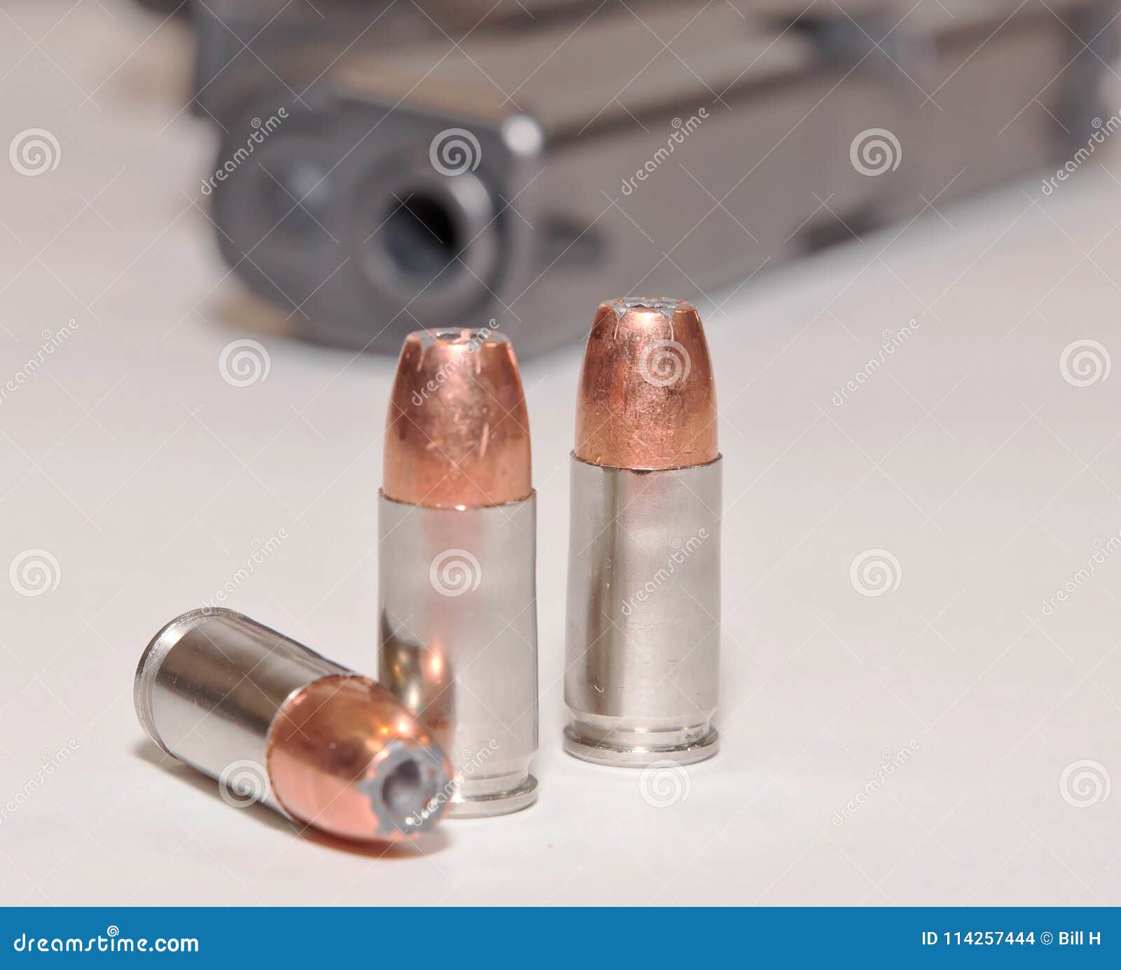 Three Bullets with a Black Pistol in the Background Stock Photo - Image ...