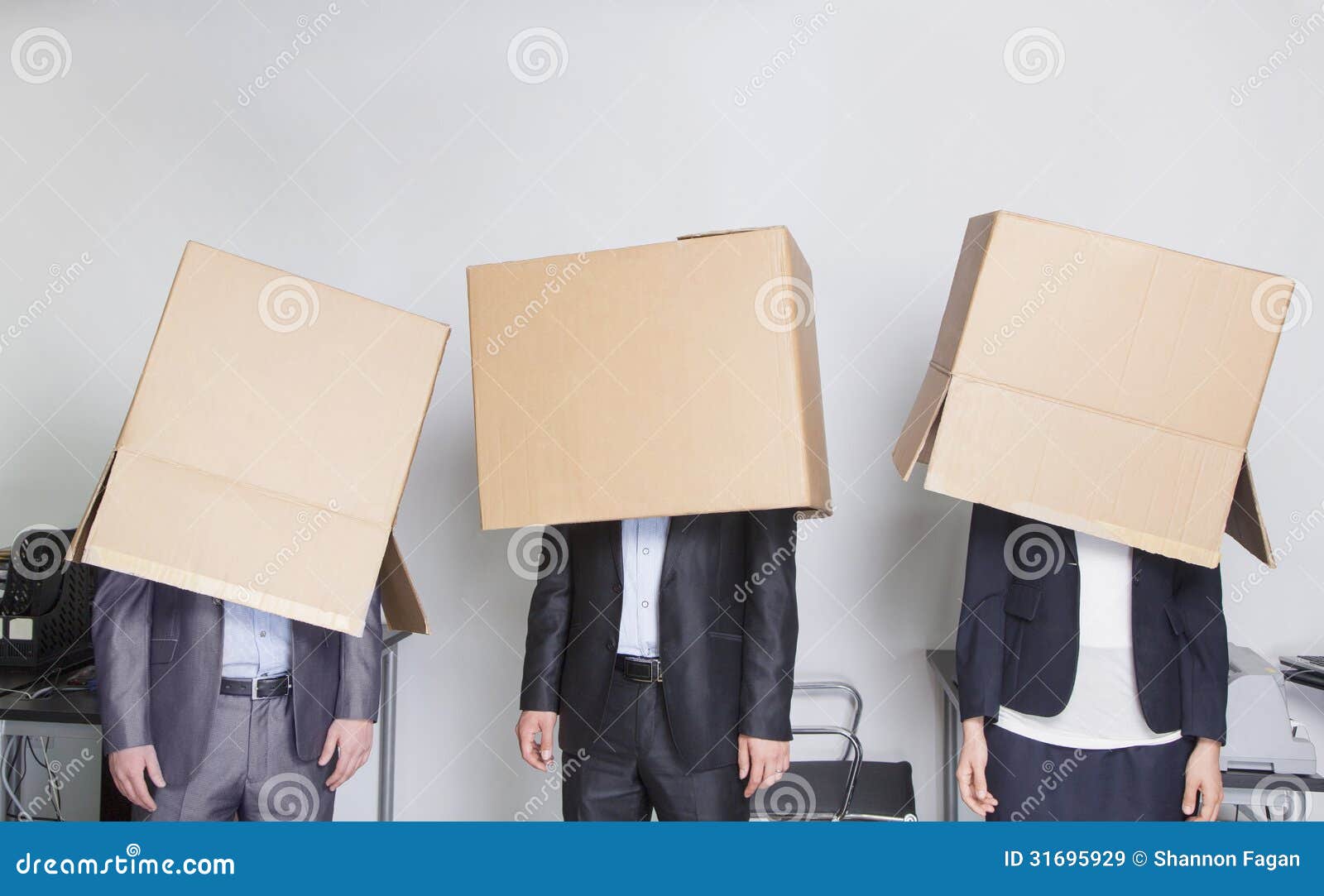 Three Business People with Boxes Over Their Heads in an Office Stock ...